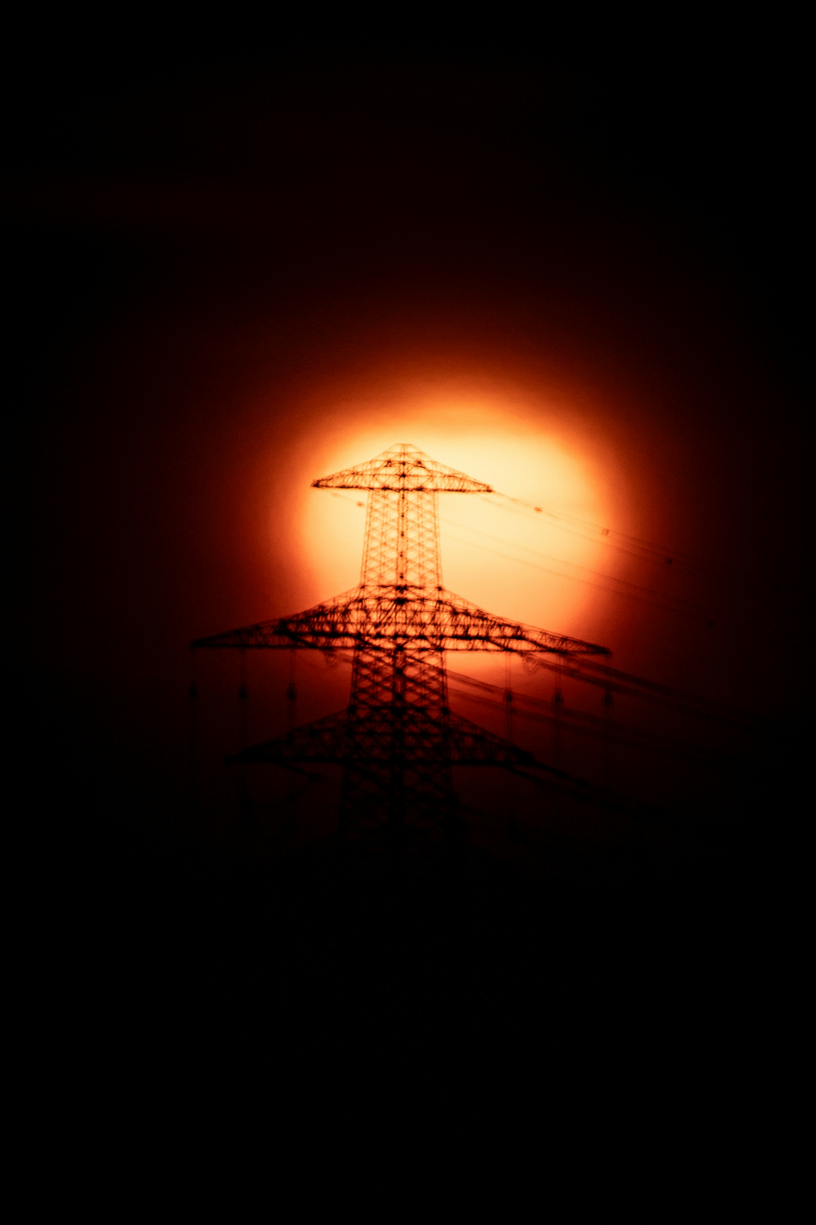 Sunlit silhouette: a lattice tower framed by a fiery halo