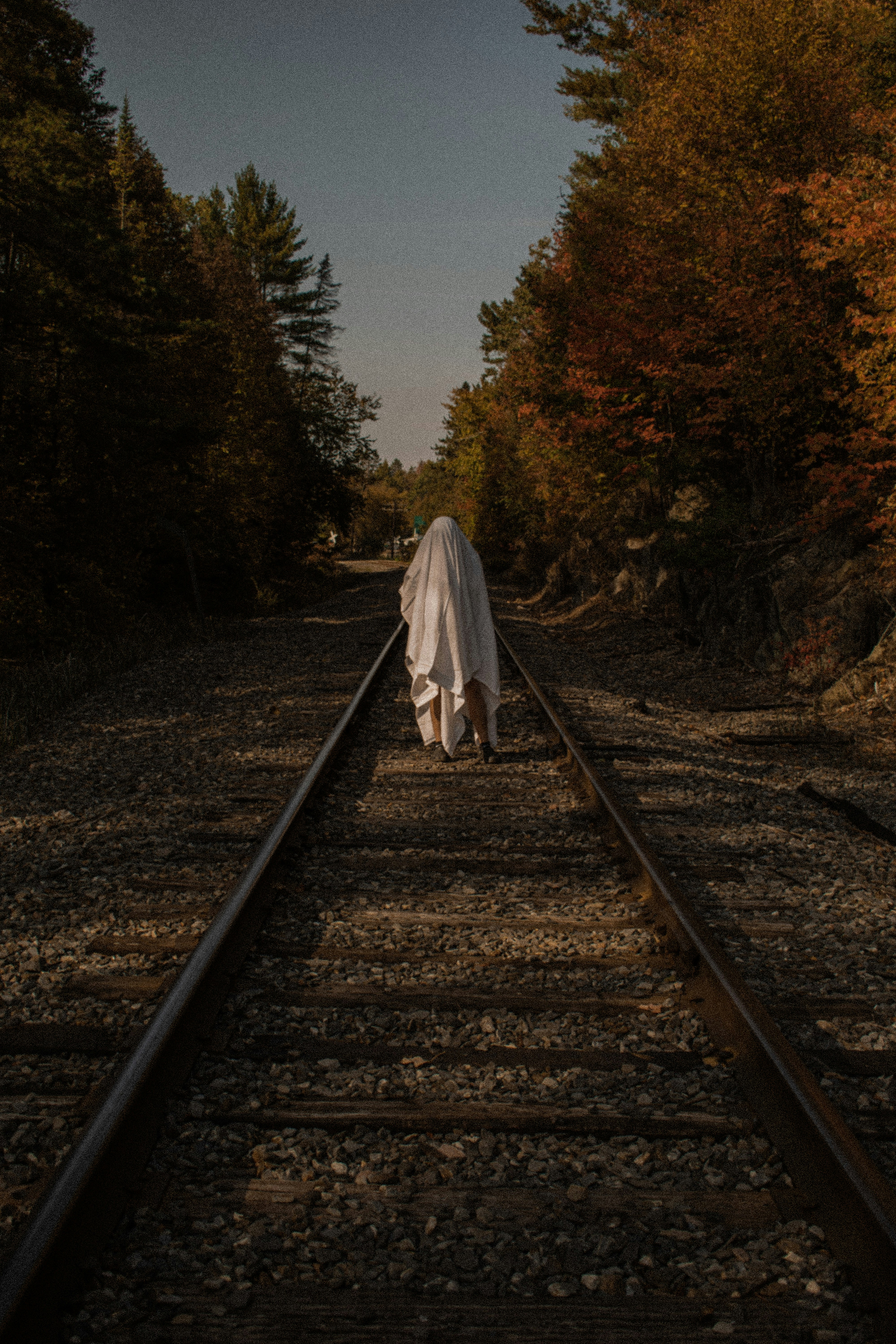 Silent Figure on the Rails: A Veiled Walk Through Autumn Light