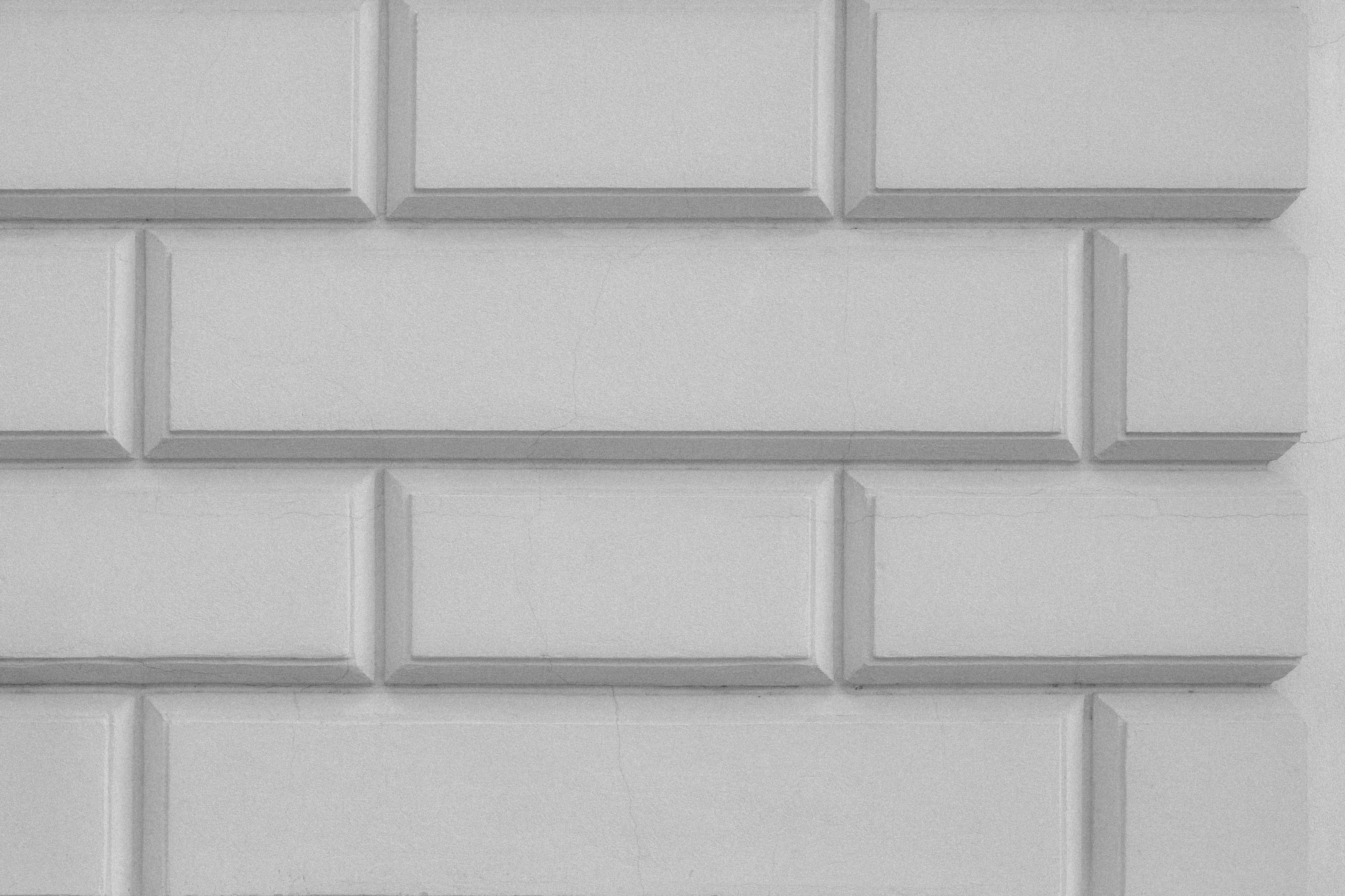 Minimalist Facade: Subtle Shadow Lines on a Gray Brick Surface