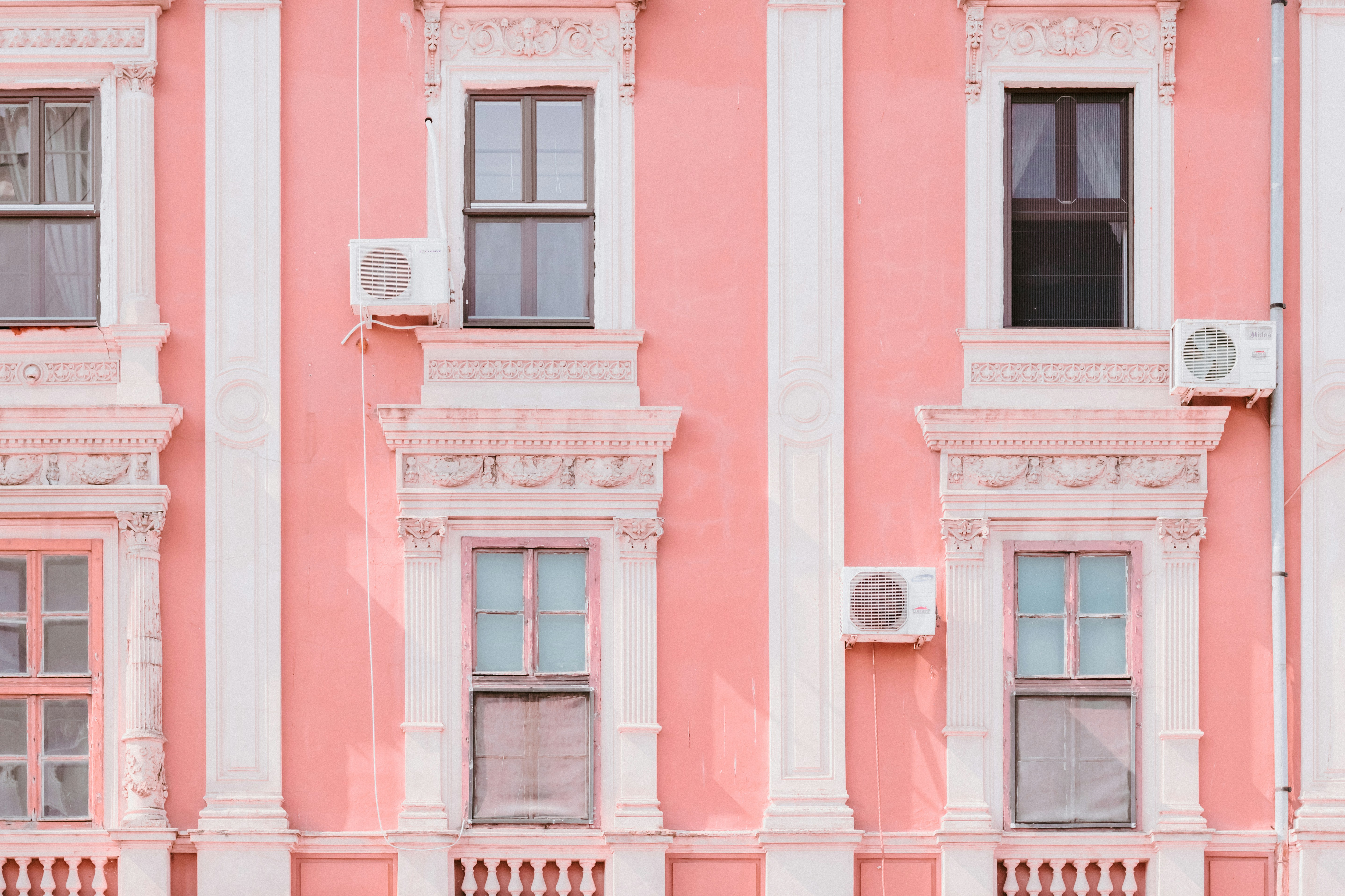 Pink Facade with Ornate White Trim and Air Conditioning Units