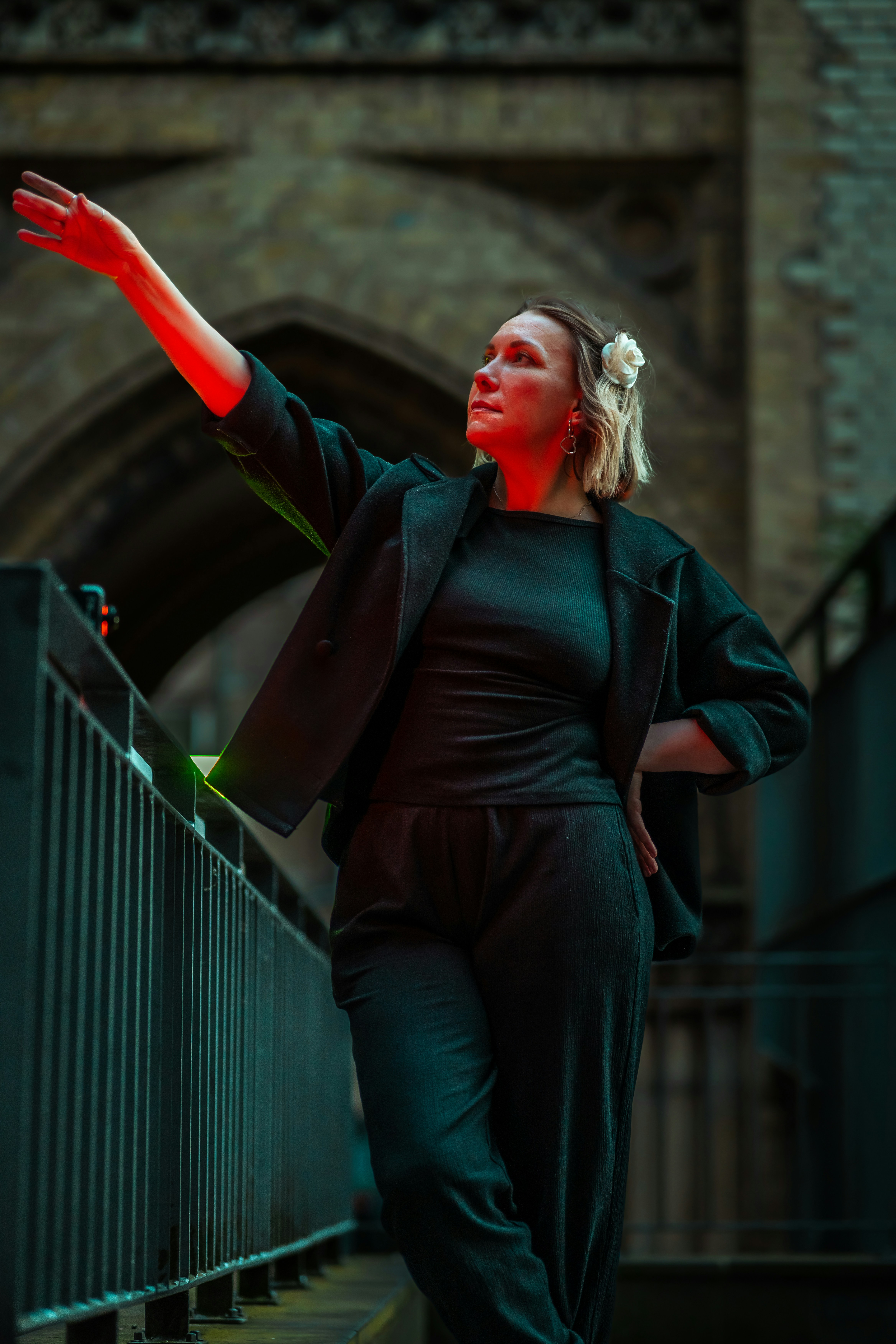 Raised Arm, Nightfall Courtyard: A Poised Figure in Red-tinged Light