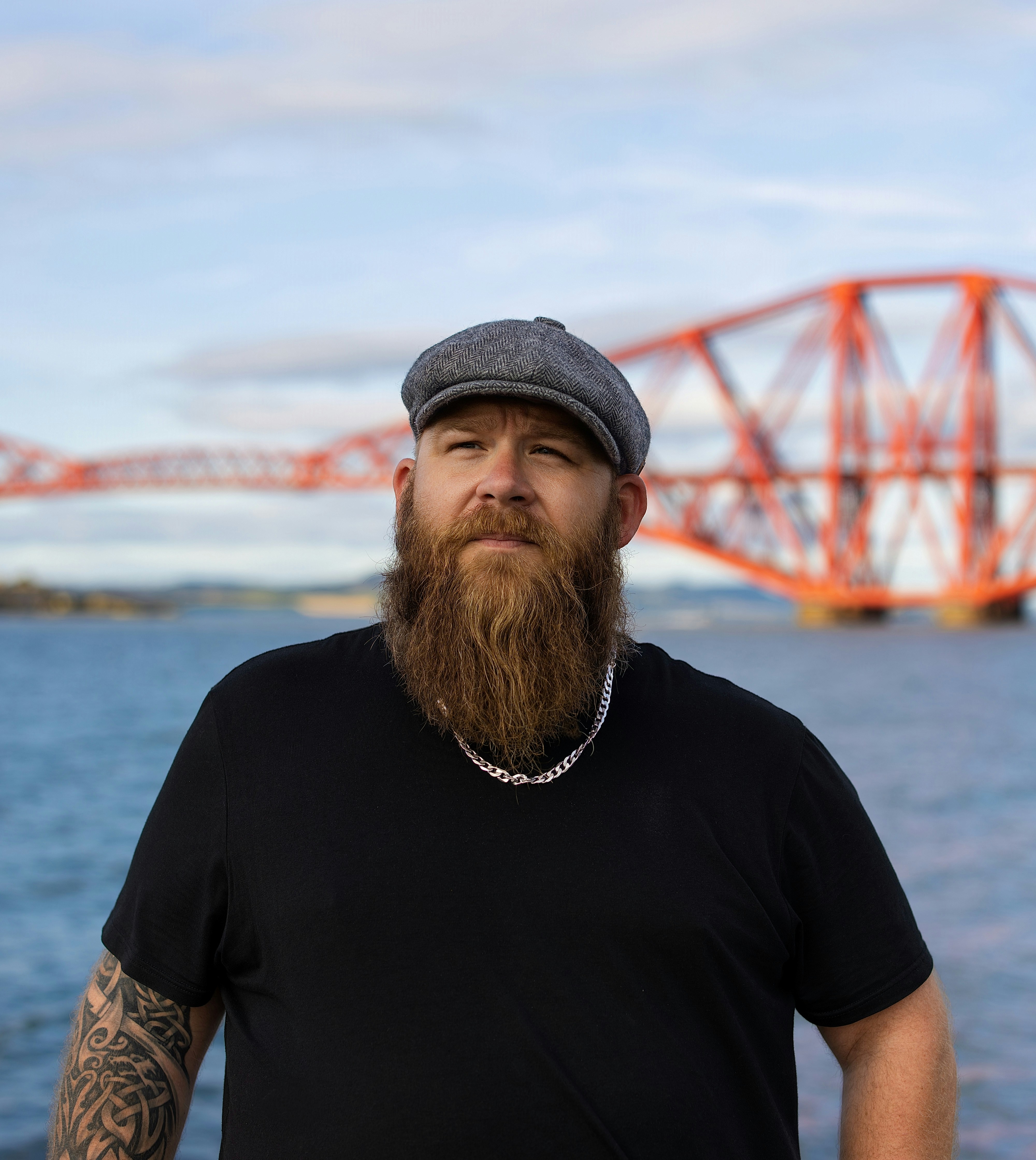 Bearded Portrait by the Waterfront with a Bright Red Bridge