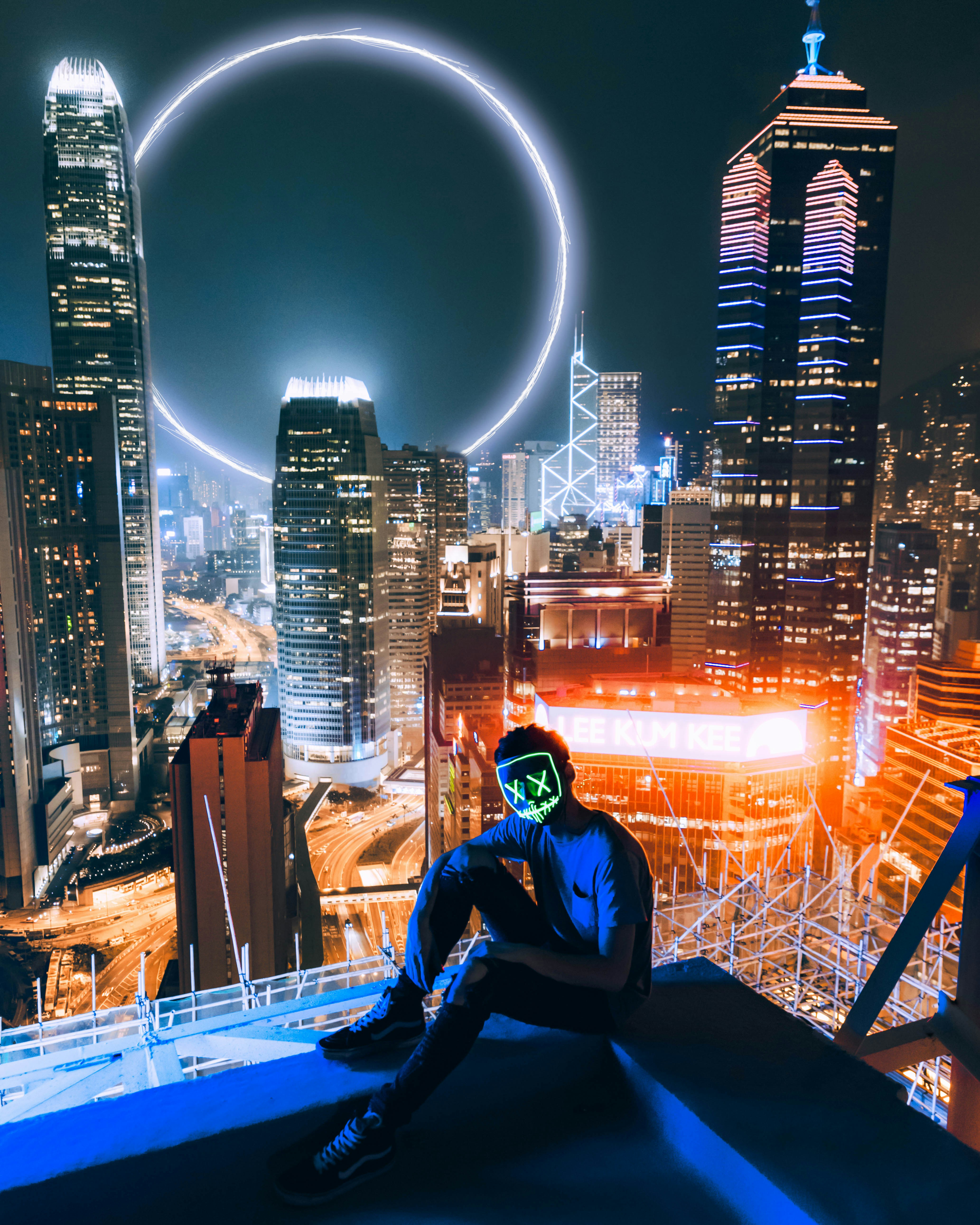 Neon Silhouette on the Rooftop: City Lights and a Circular Halo