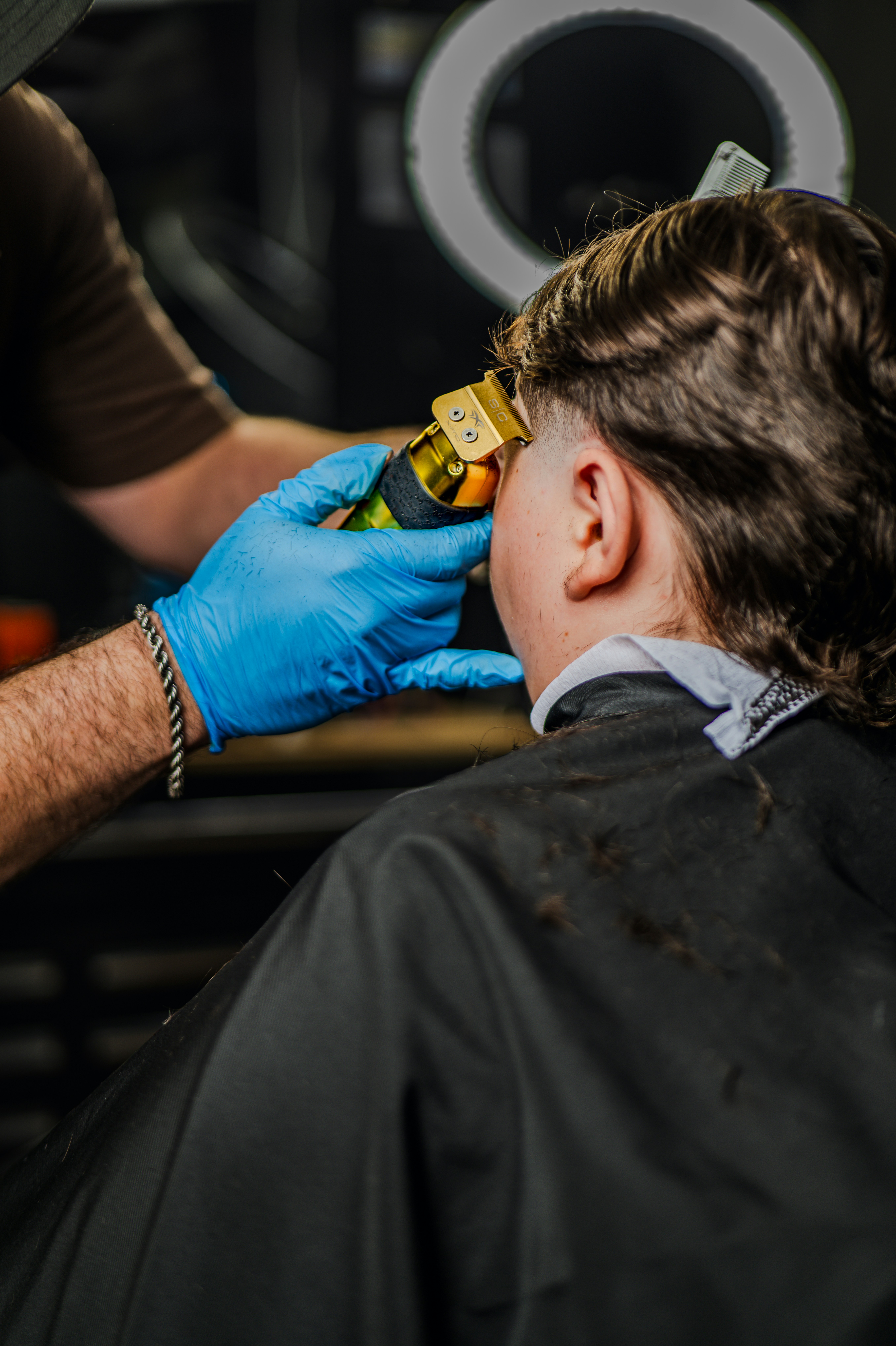 Precision in Focus: a barber’s precision tool glides at forehead level