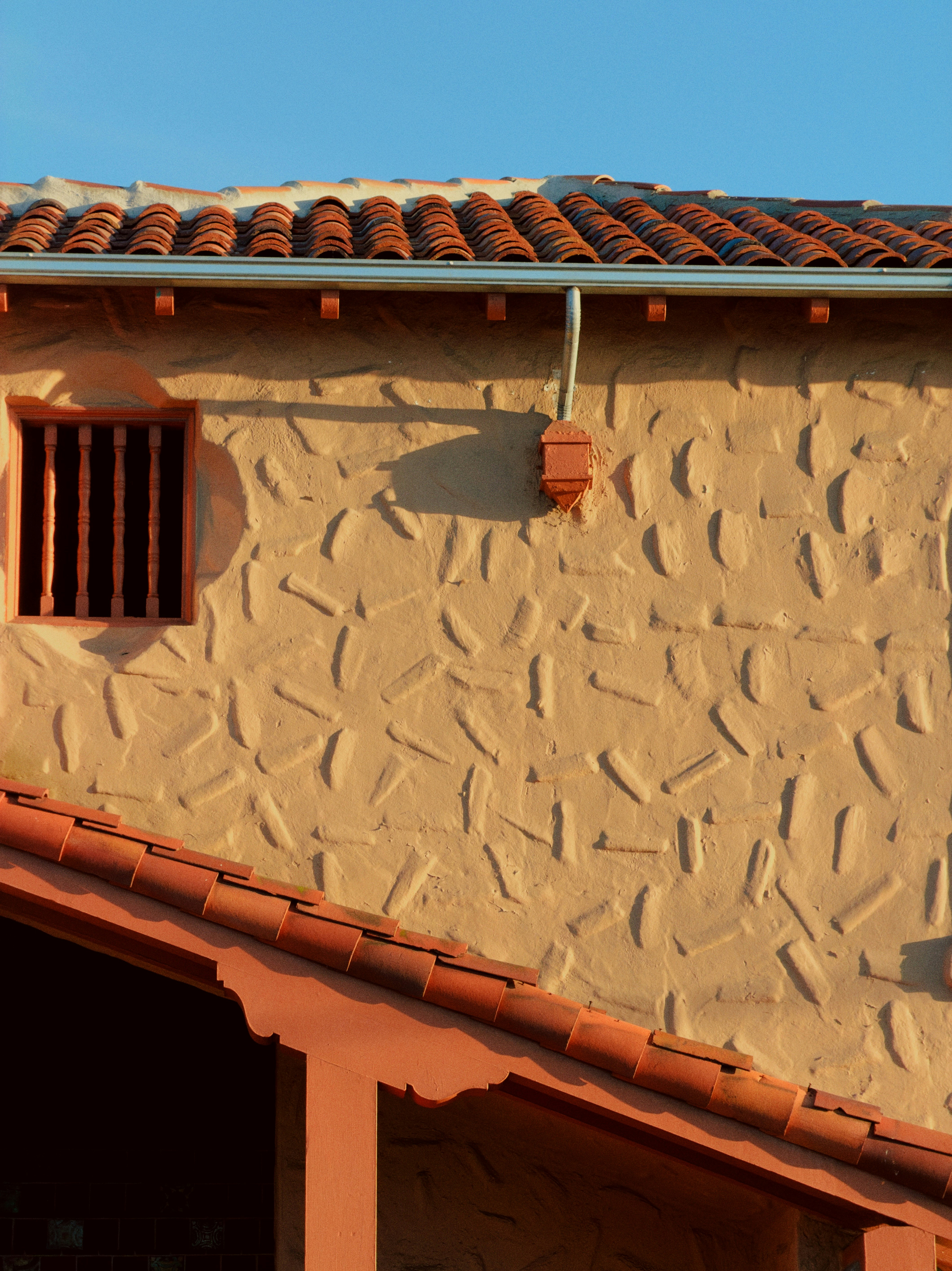 Sunlit stucco textures and terracotta roofline