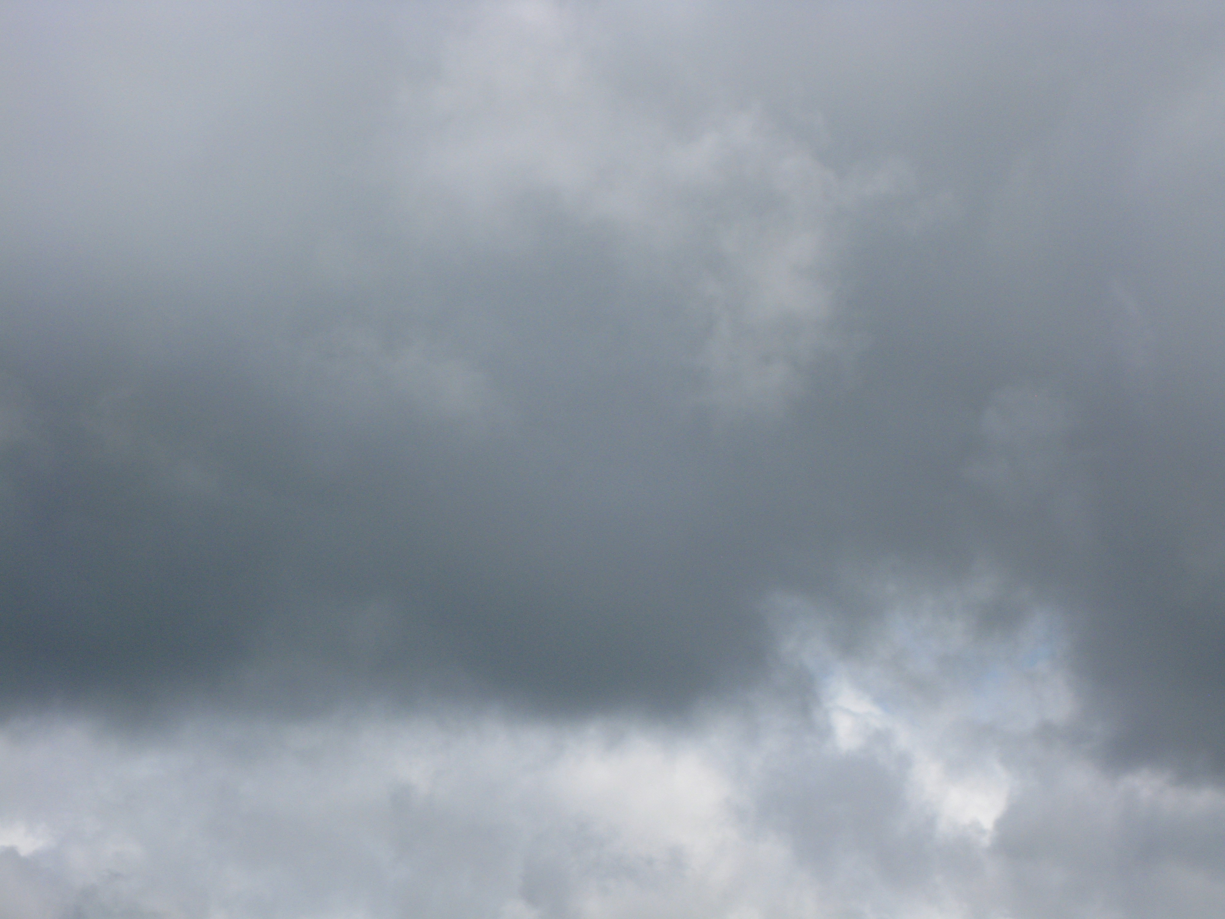 Soft, heavy clouds dominate the frame with a sliver of brighter sky near the lower right; minimal scene context, focusing on the moody atmospheric sky.