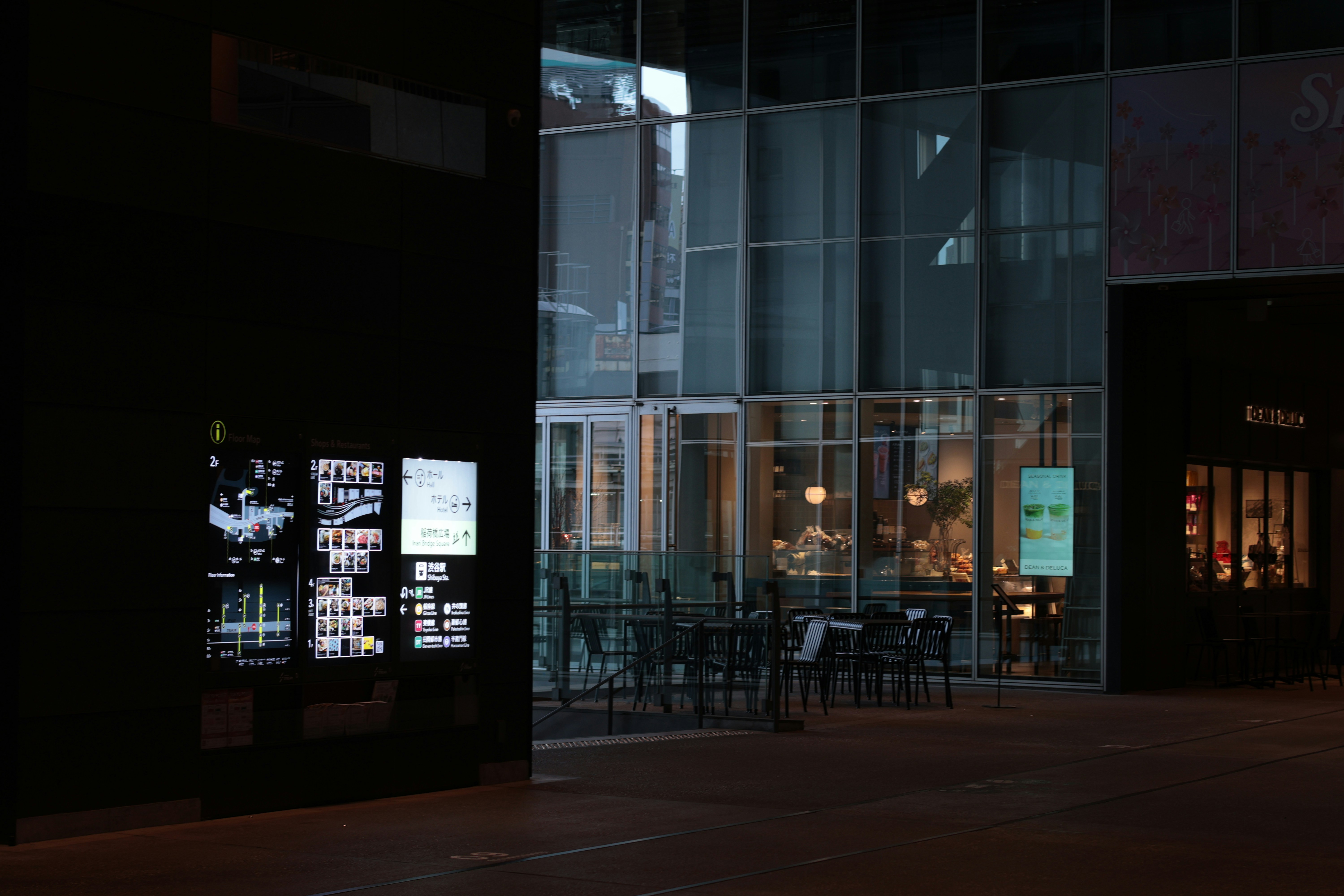 Glass Facade at Dusk: Quiet Café Illuminated Beneath Night Sky