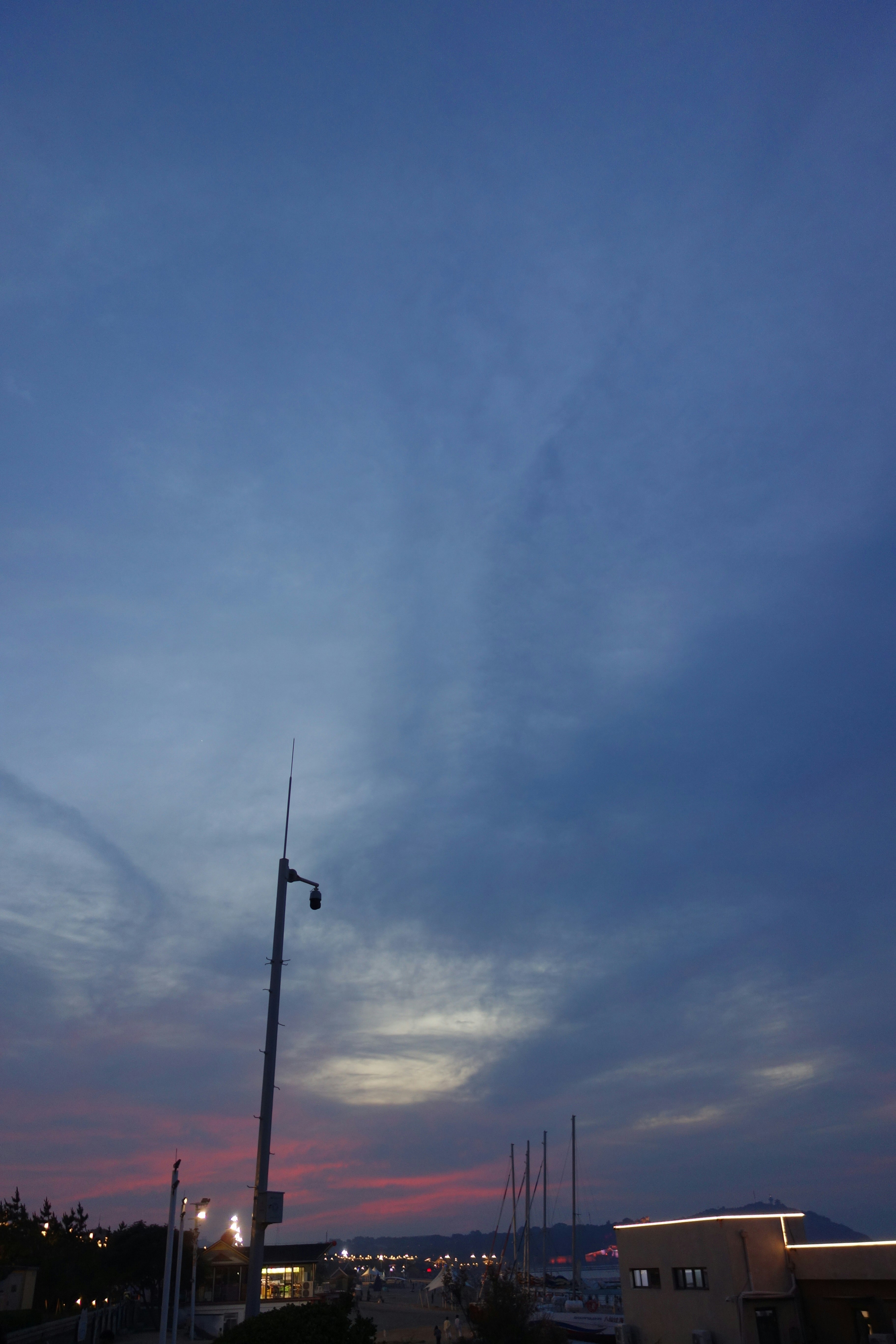 Pole of Light: Marina Sunset Under a Wide Sky
