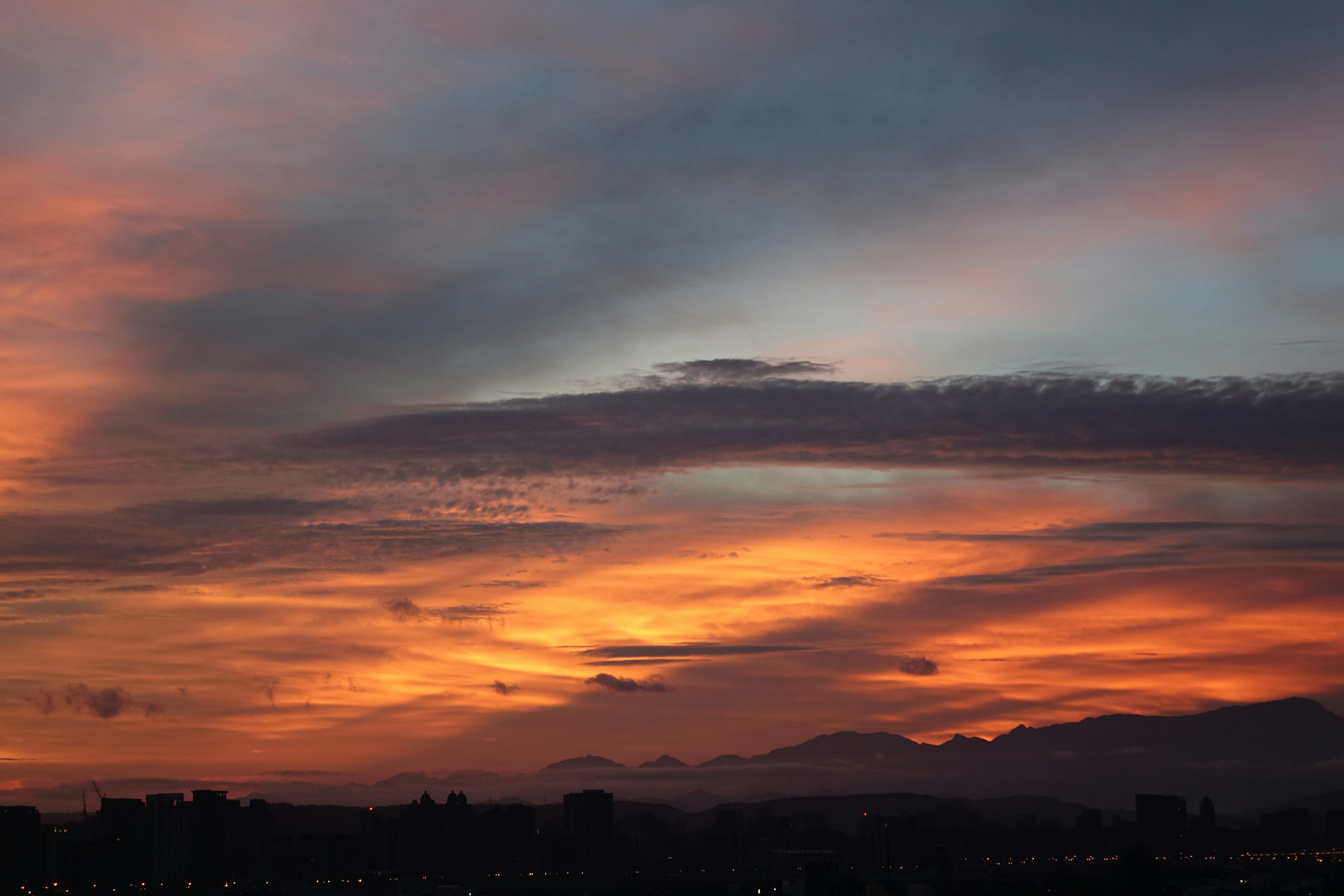 Glowing Horizon: A City Silhouette Beneath a Fiery Sky