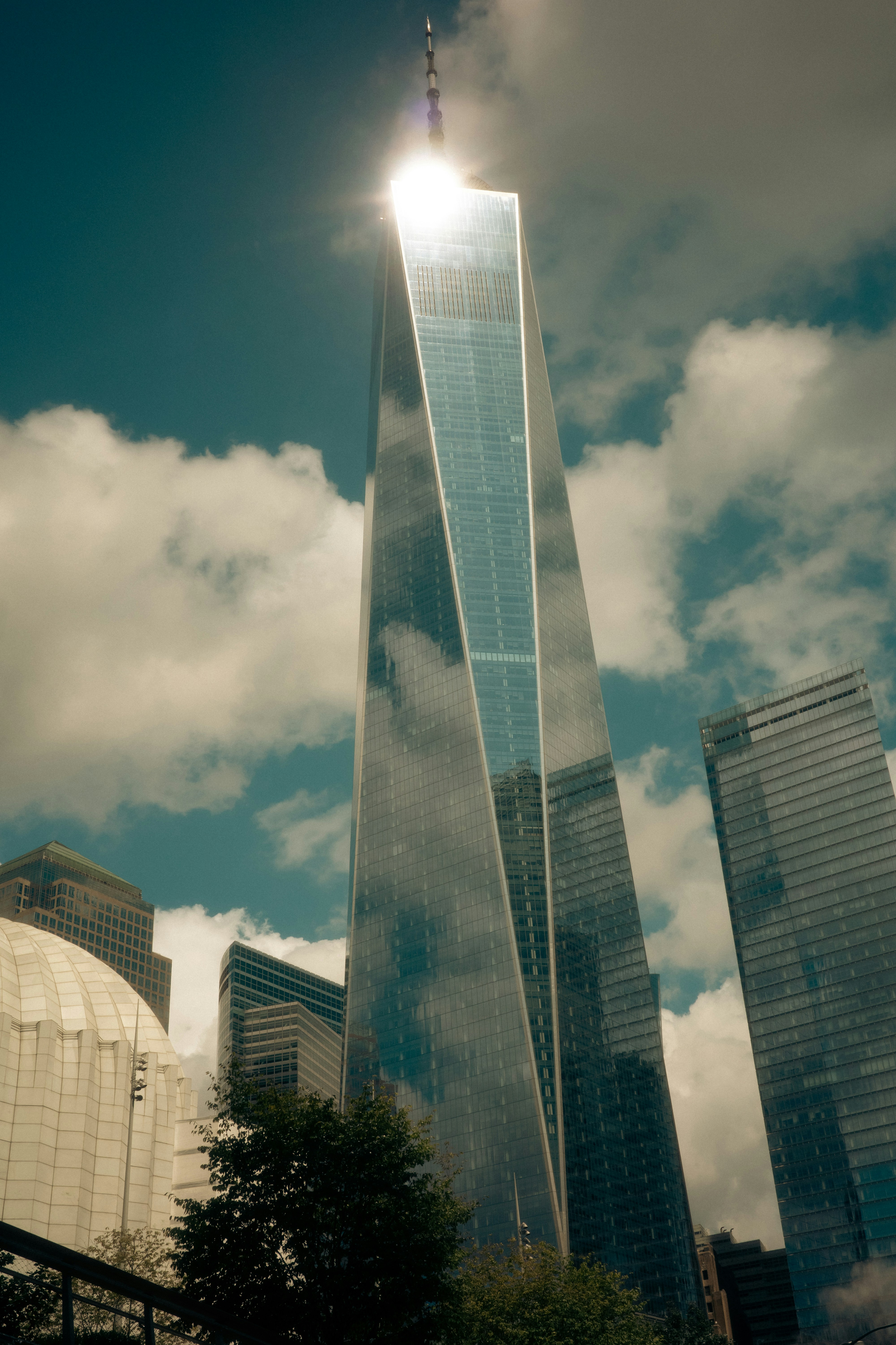 Skyward Glass: The Spire Pierces a Blue-White Sky