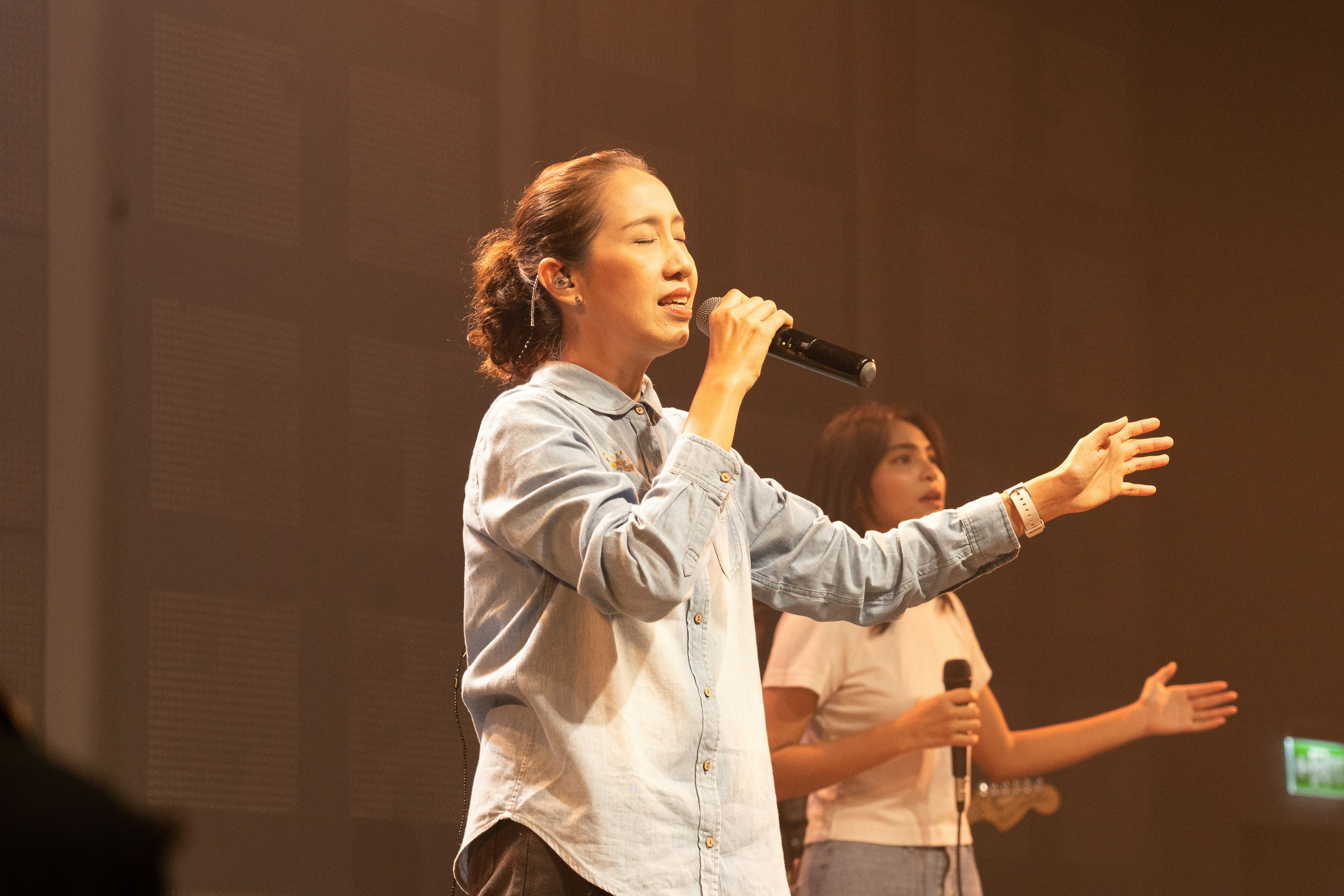 Candid Hymns: Vocalist taking center stage under warm stage lights