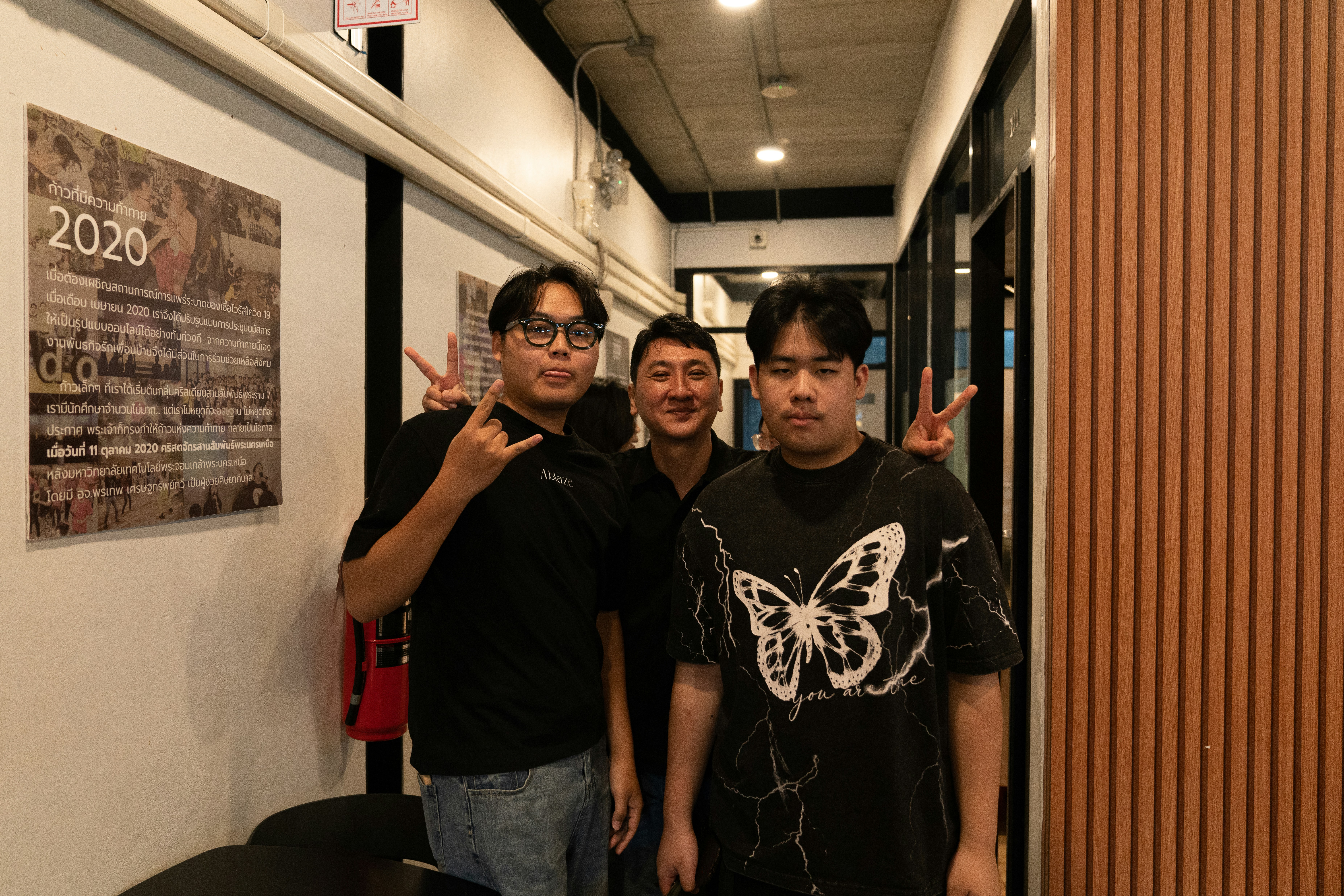 Three Friends in a Narrow Corridor Share a Quiet Victory Pose