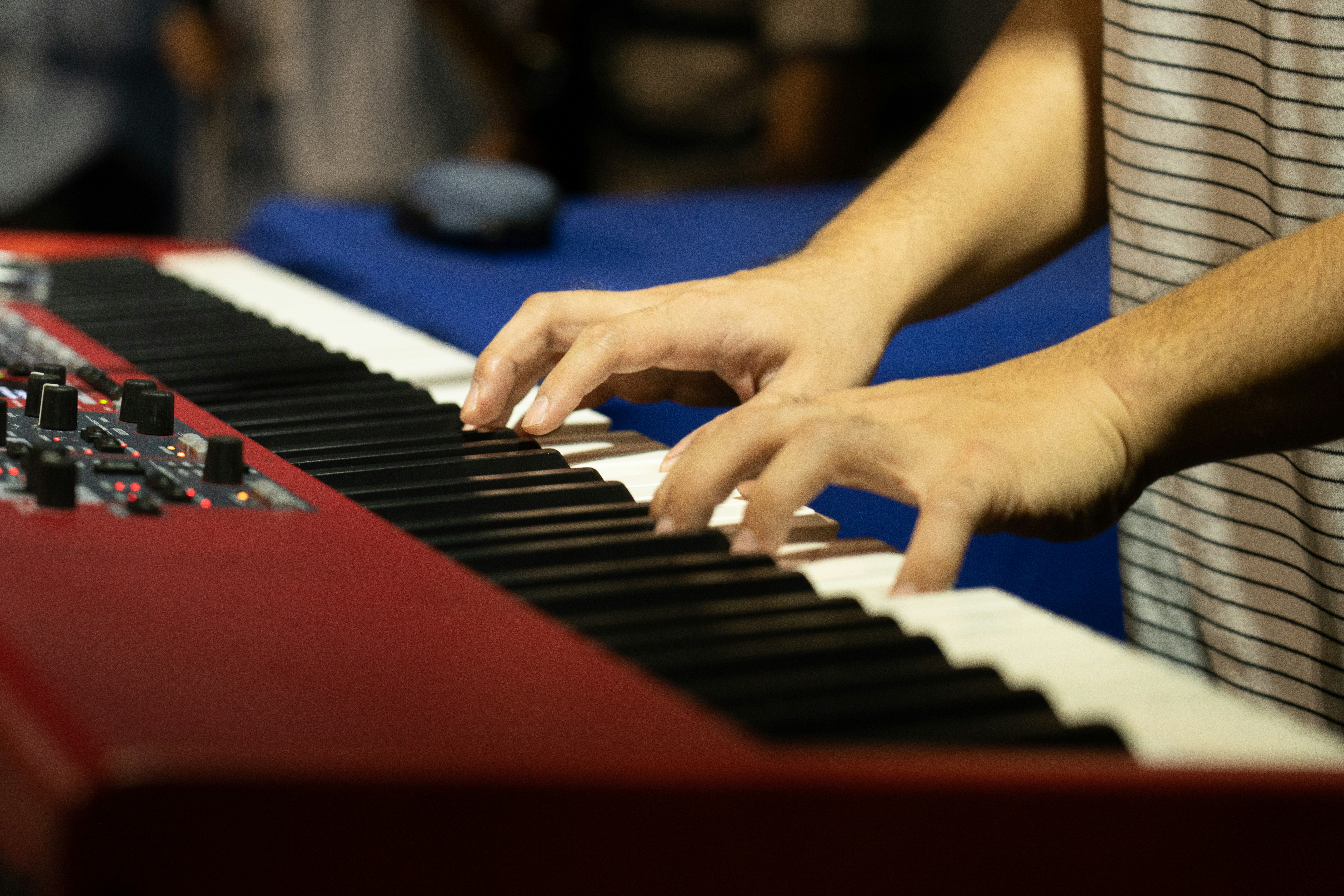 Keys in Focus: Hands Dancing Across a Red Keyboard