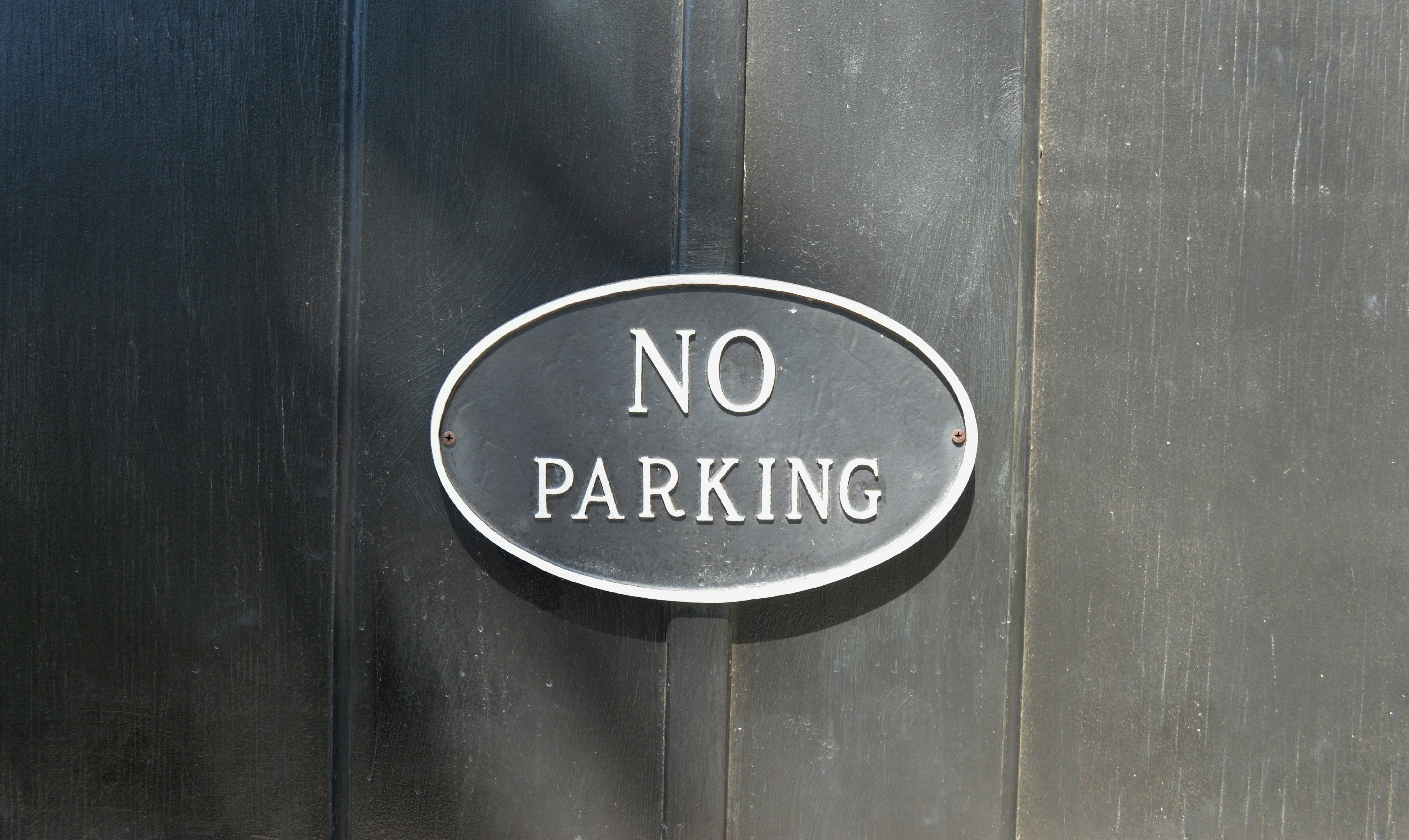 No Parking Sign on Weathered Wooden Gate