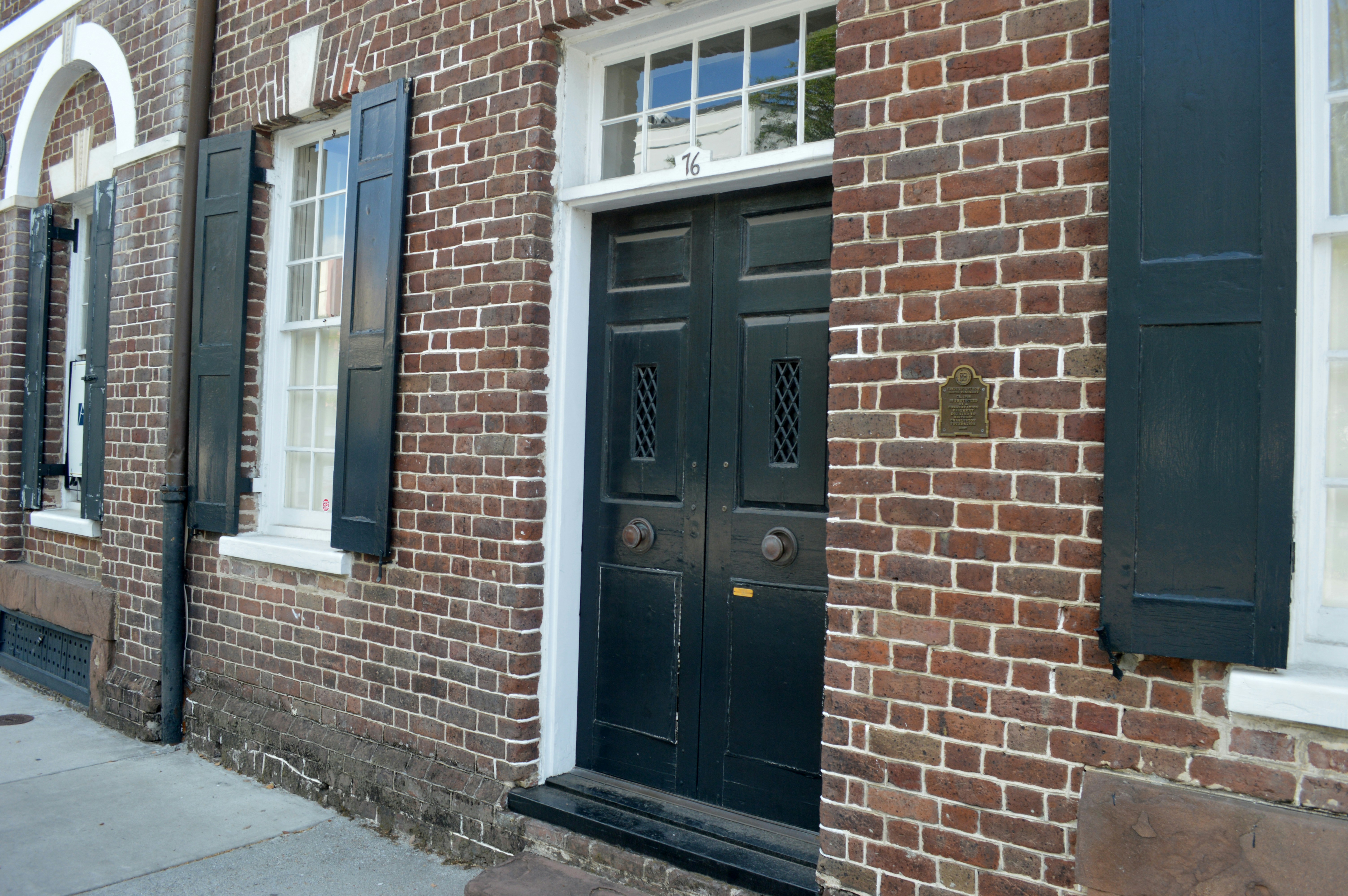 Brick Facade and Dark Door: A Quiet Street’s Central Threshold