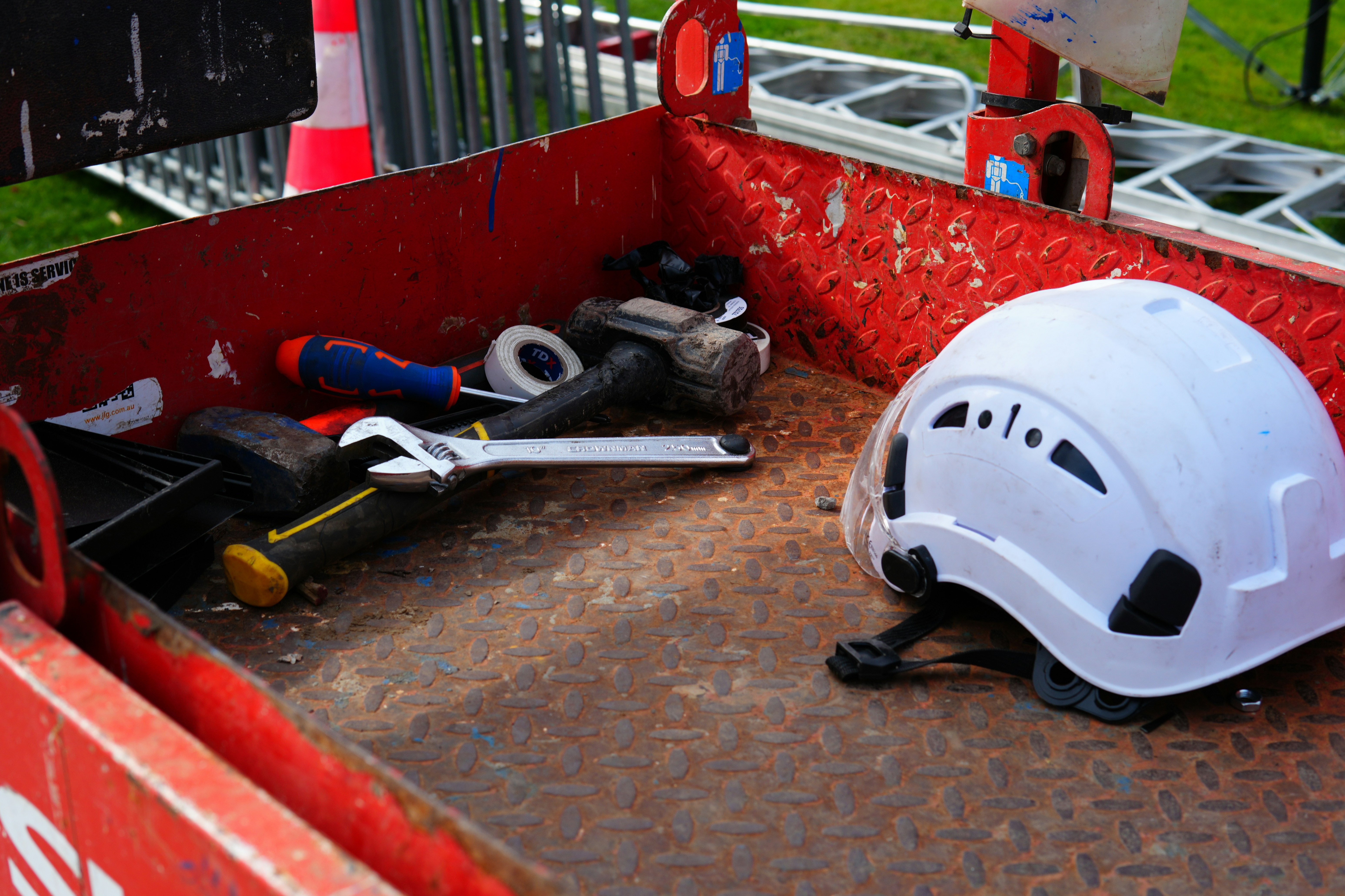Red Work Tray: Tools Resting Beside a White Safety Helmet