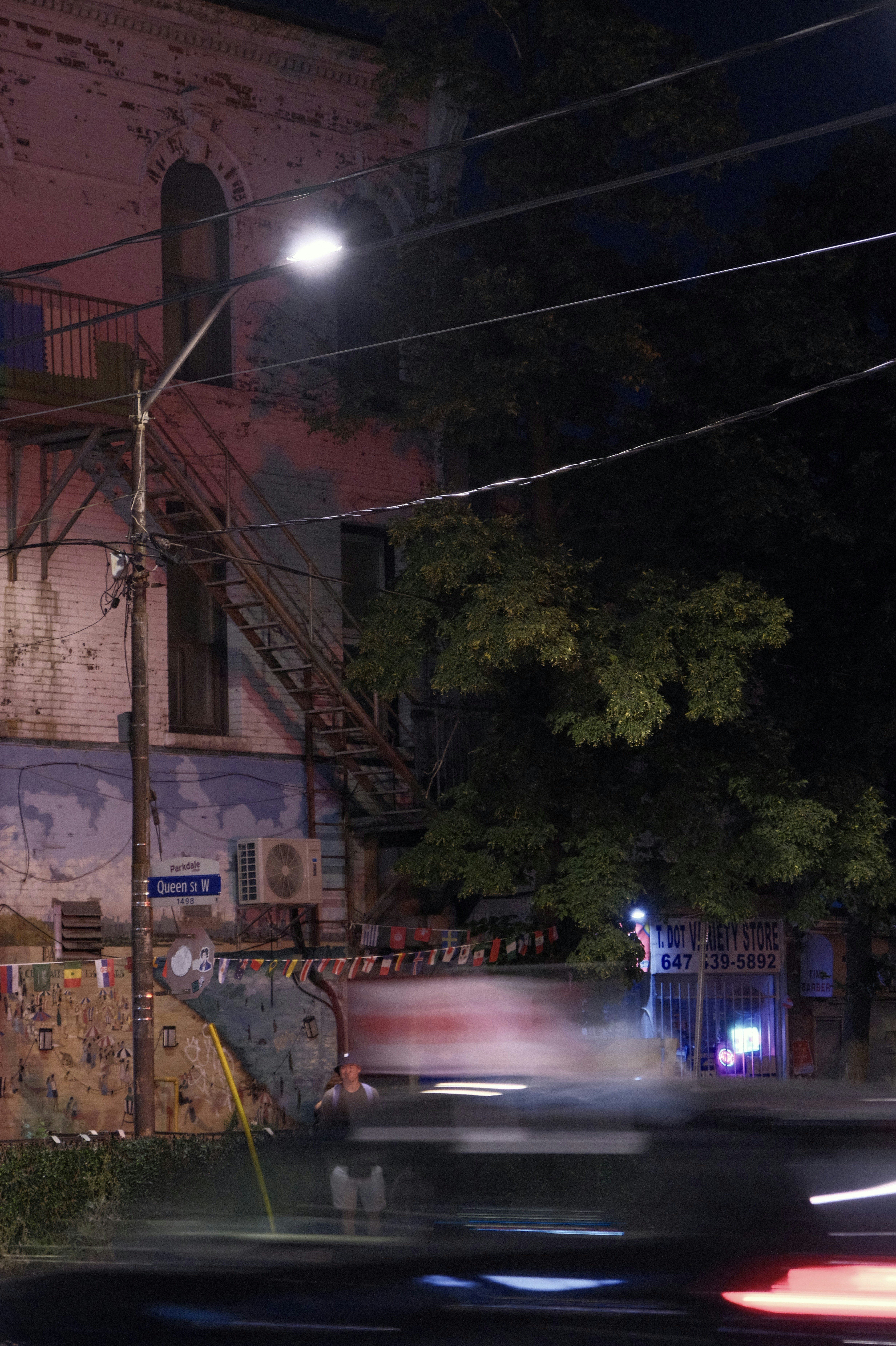 Night Street Scene: A Blurred Car Passes Beneath an Old Brick Building