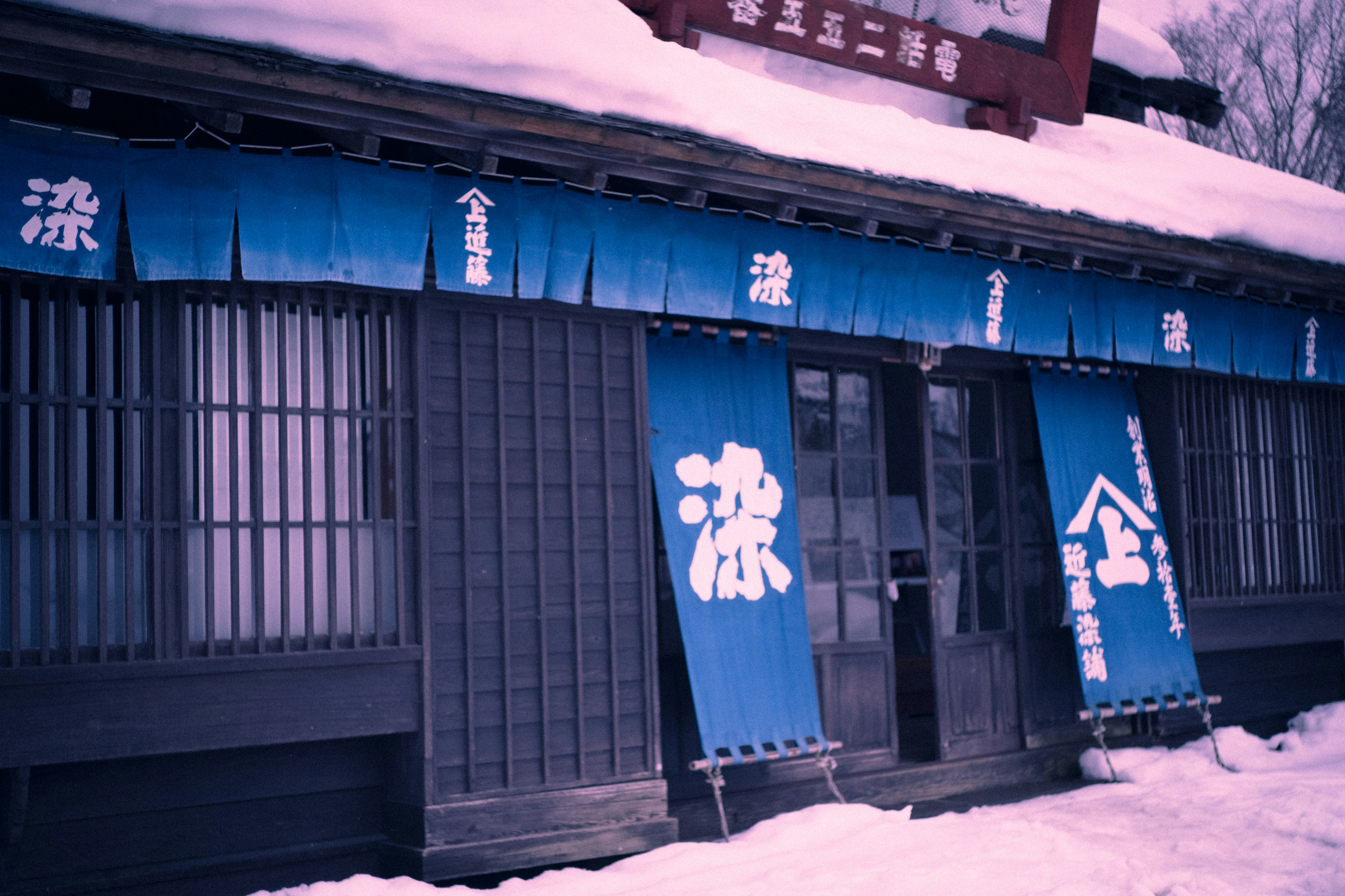 Snow-Laced Blue Noren Guarding a Quiet Japanese Alleyway