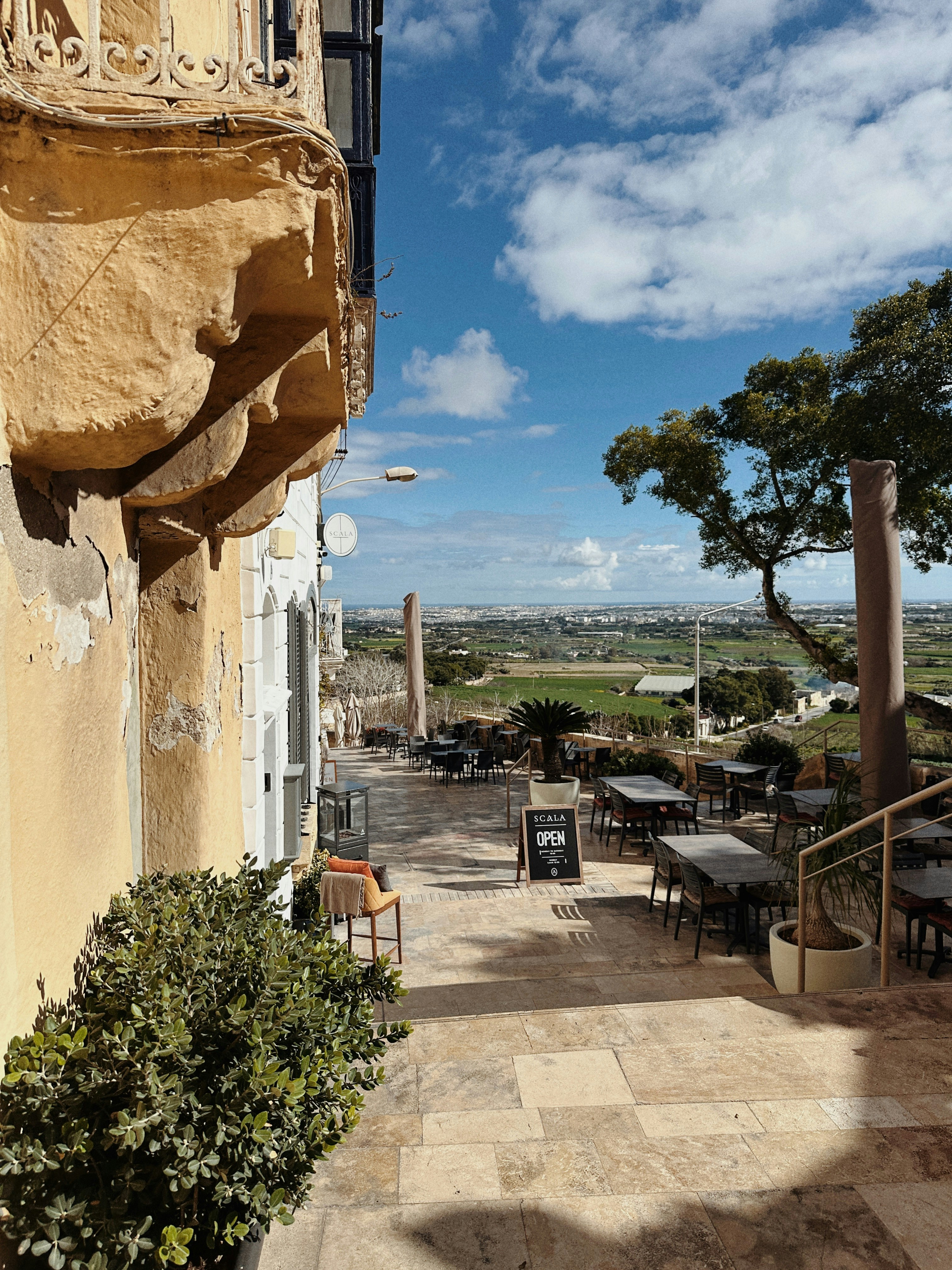 Terraced Café Overlooking a Sunlit Coastal Plain