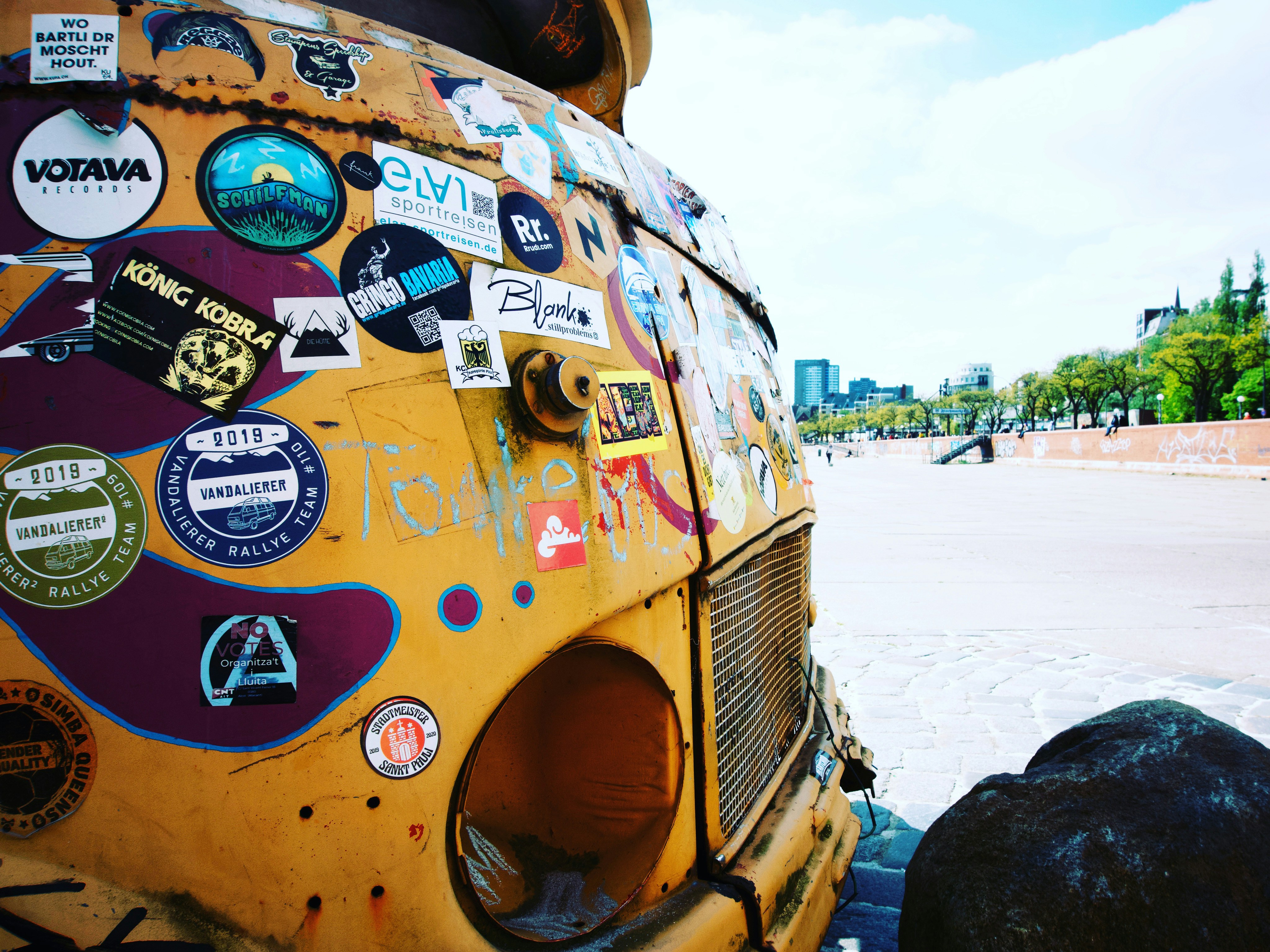 Stickered Vintage Vehicle at a Sunlit Riverside