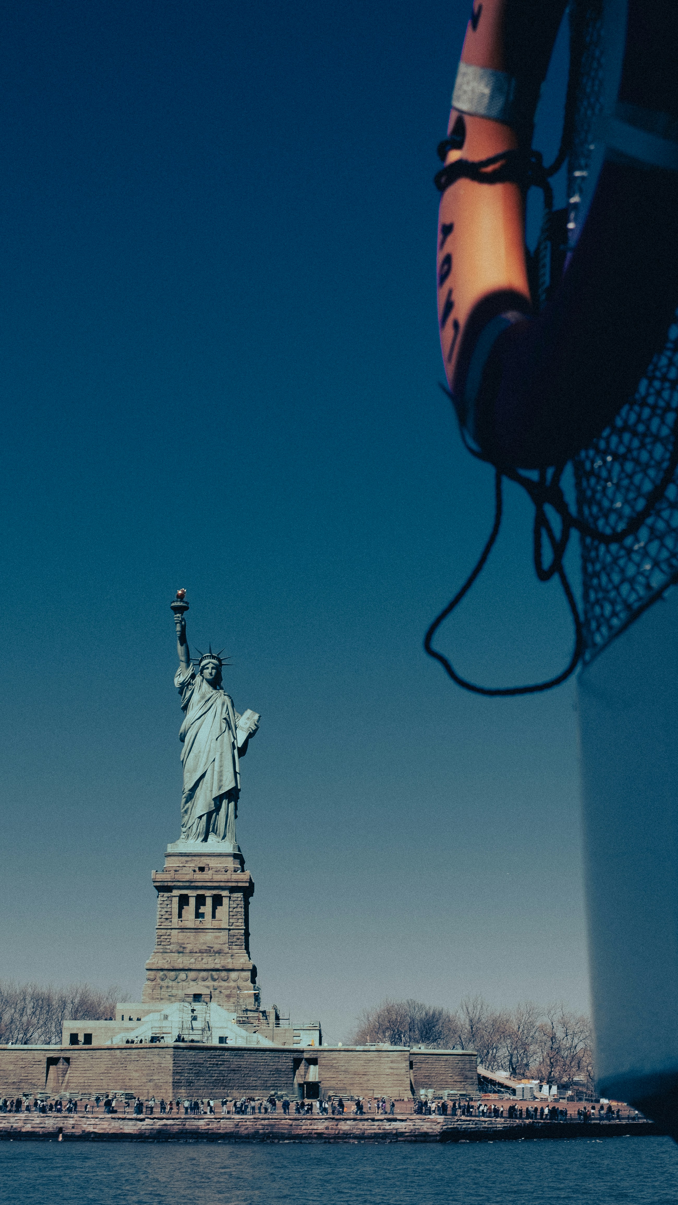 Liberty by the Waterfront: A Lone Statue Sits Under a Clear Sky