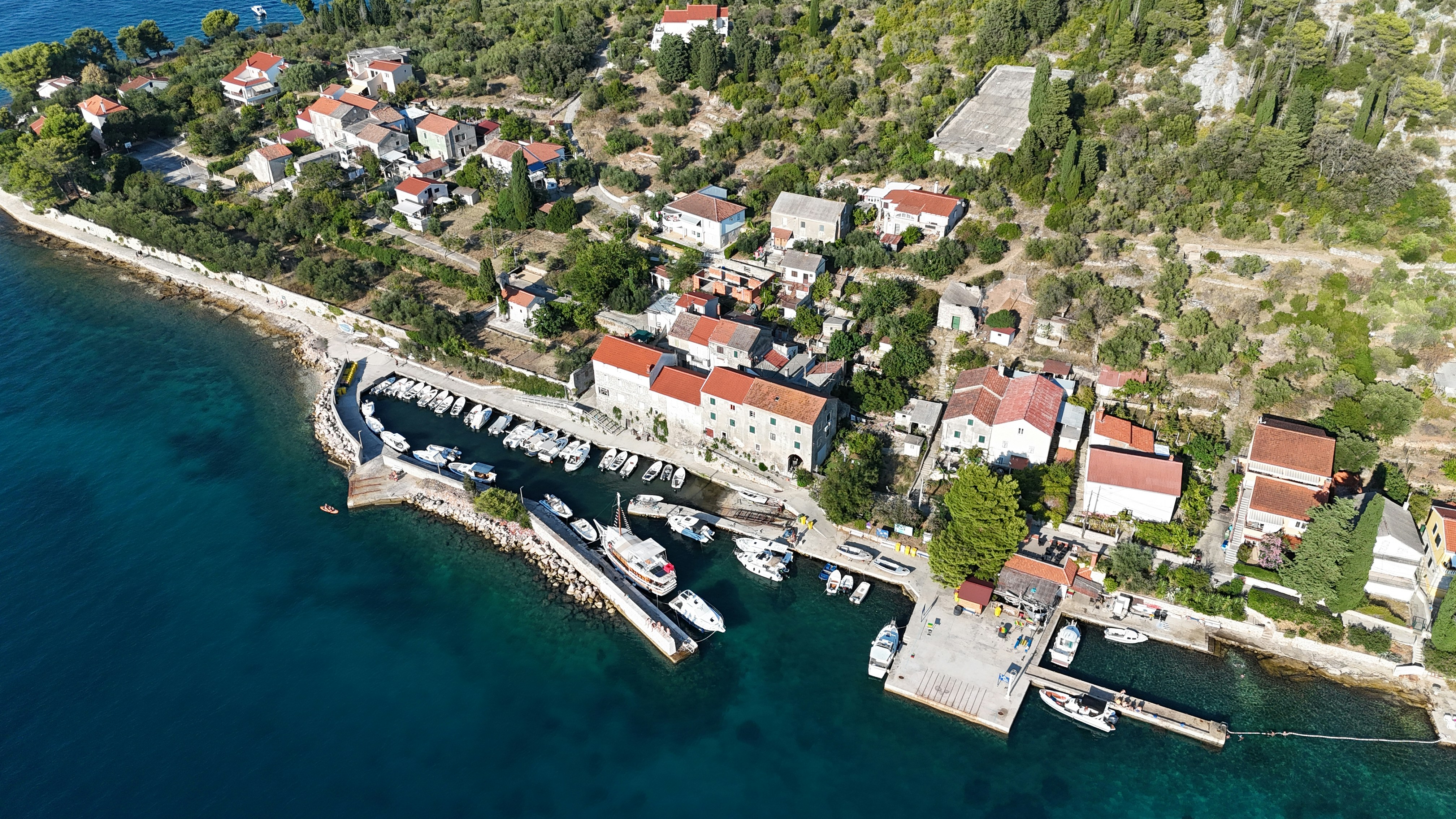 Coastal Village Harbor: Boats, quay, and terraced houses on a hillside