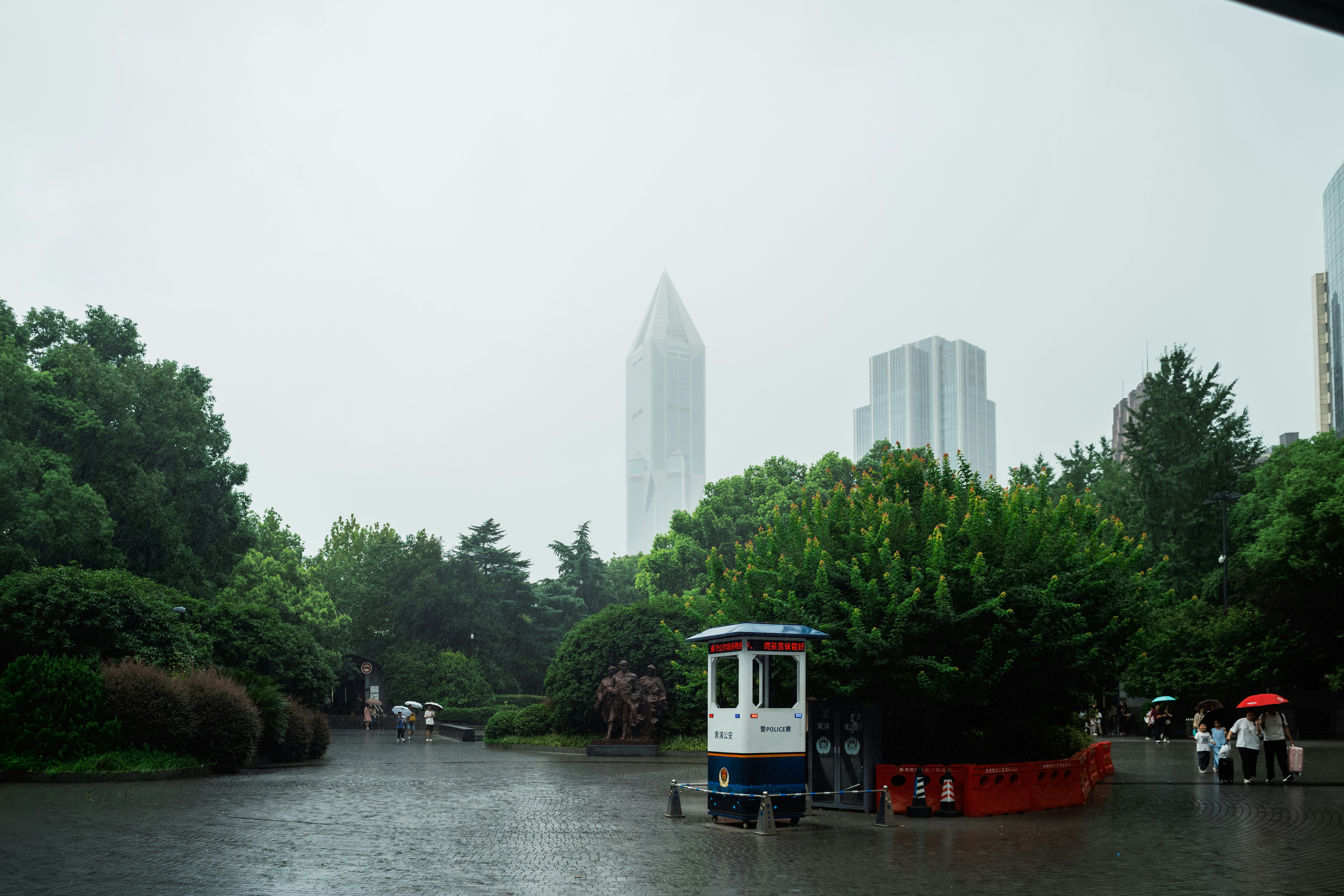 Urban Rain: A Riverside Gate Amid Parked Trams