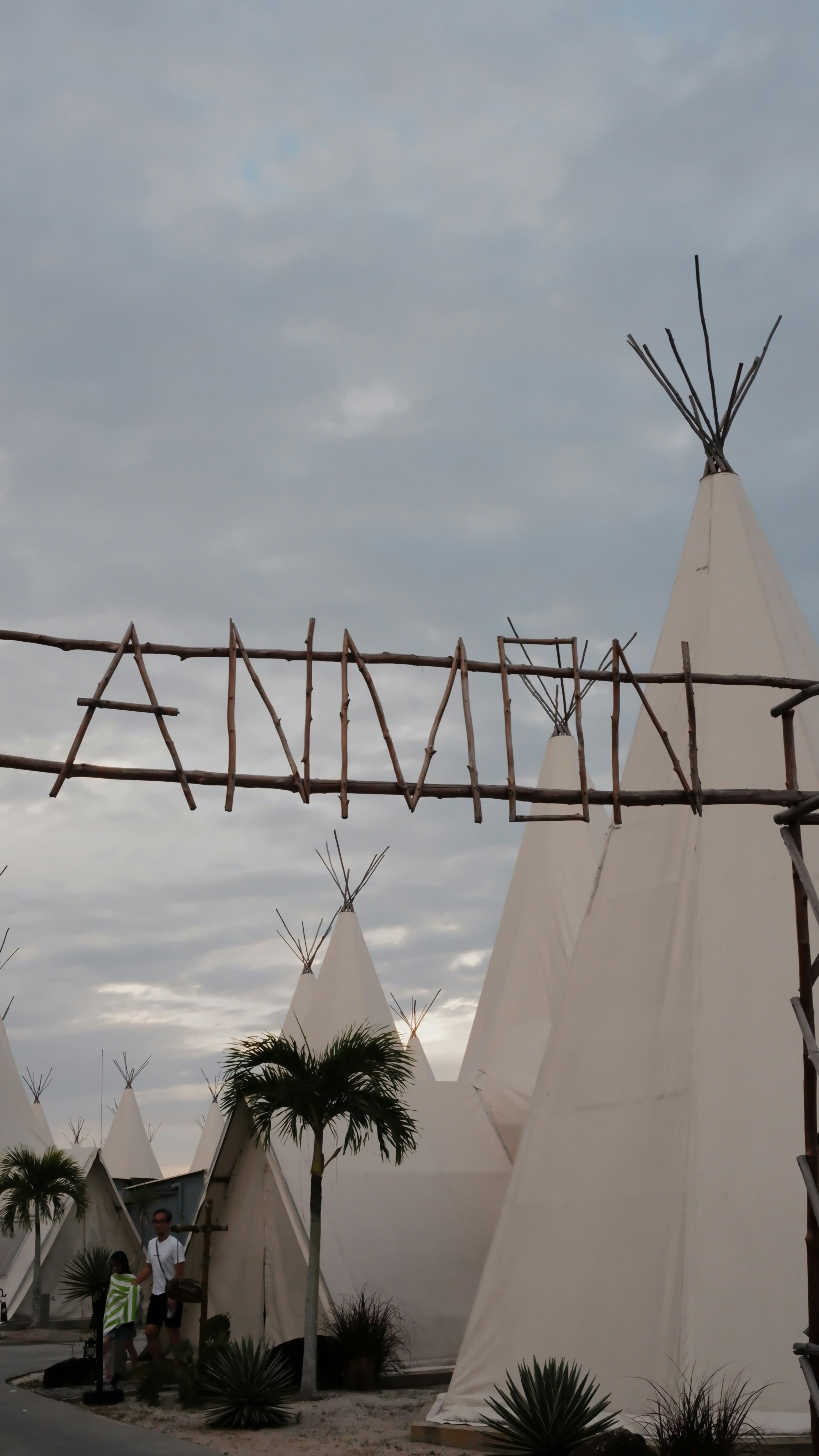 Tented Gateway: A Row of White Tipis Under a Cloudy Sky