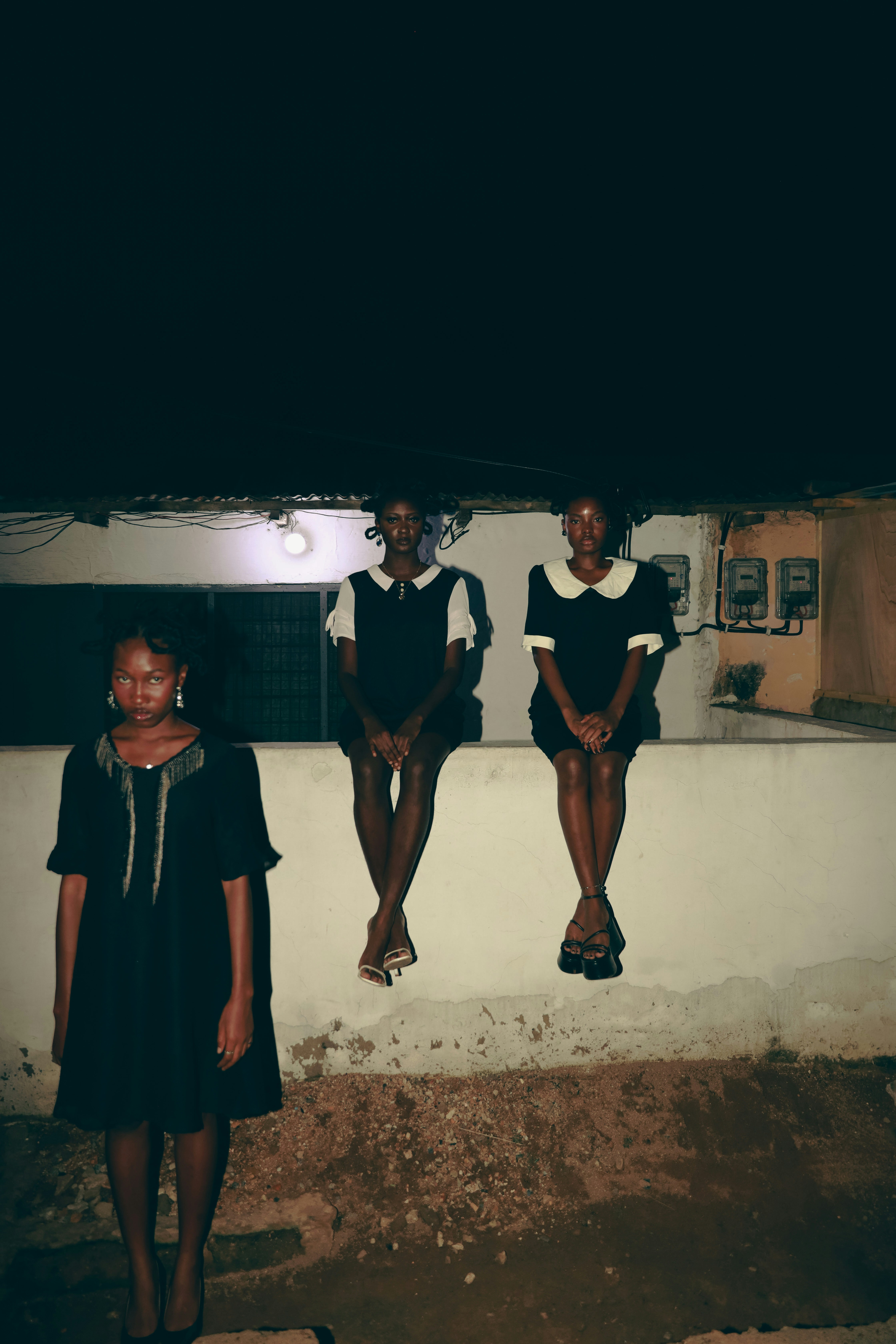 Three Quiet Figures on a Rooftop Edge at Dusk