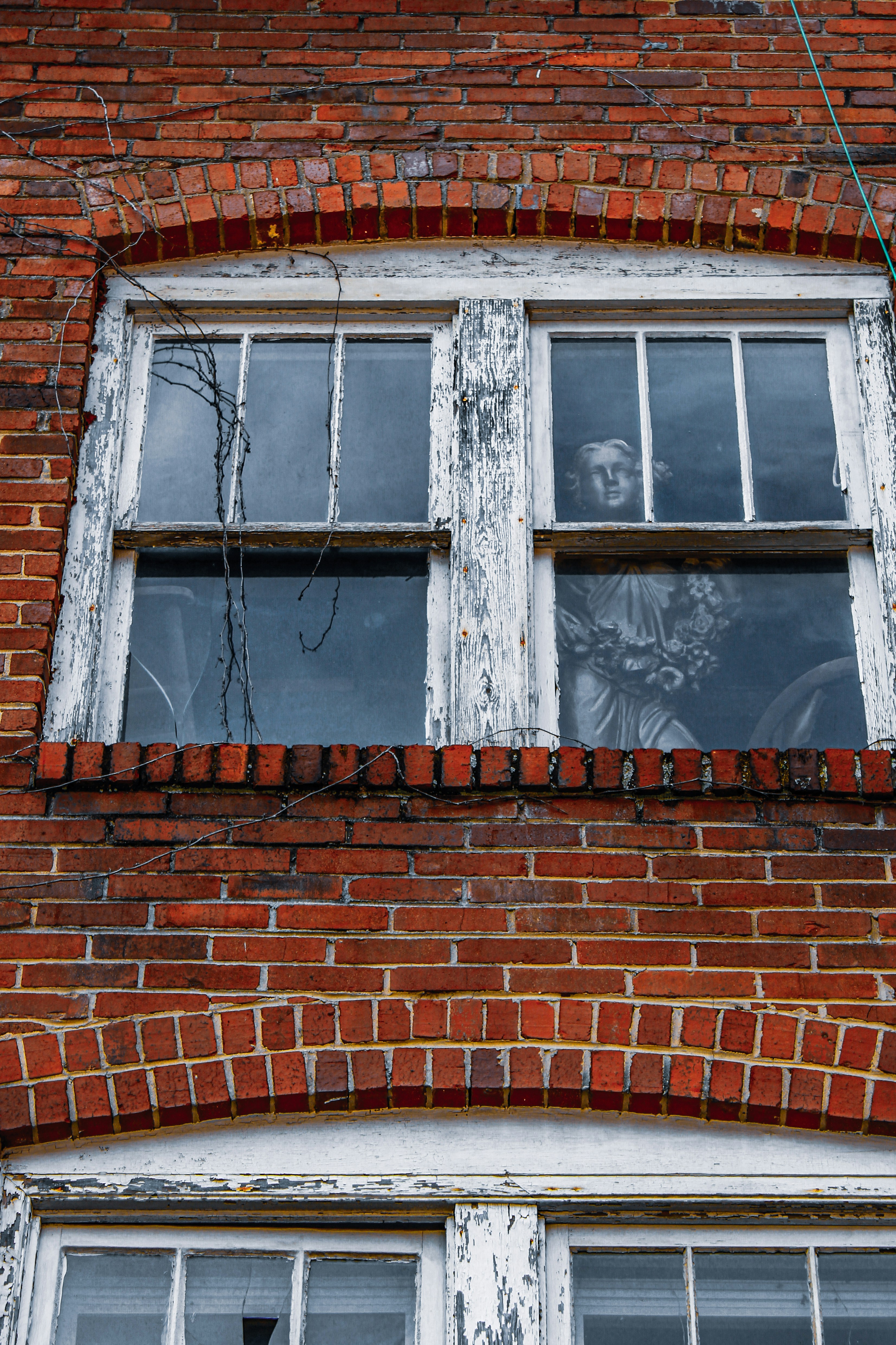 Ghost in the Glass: A Weathered Window with a Faded Portrait