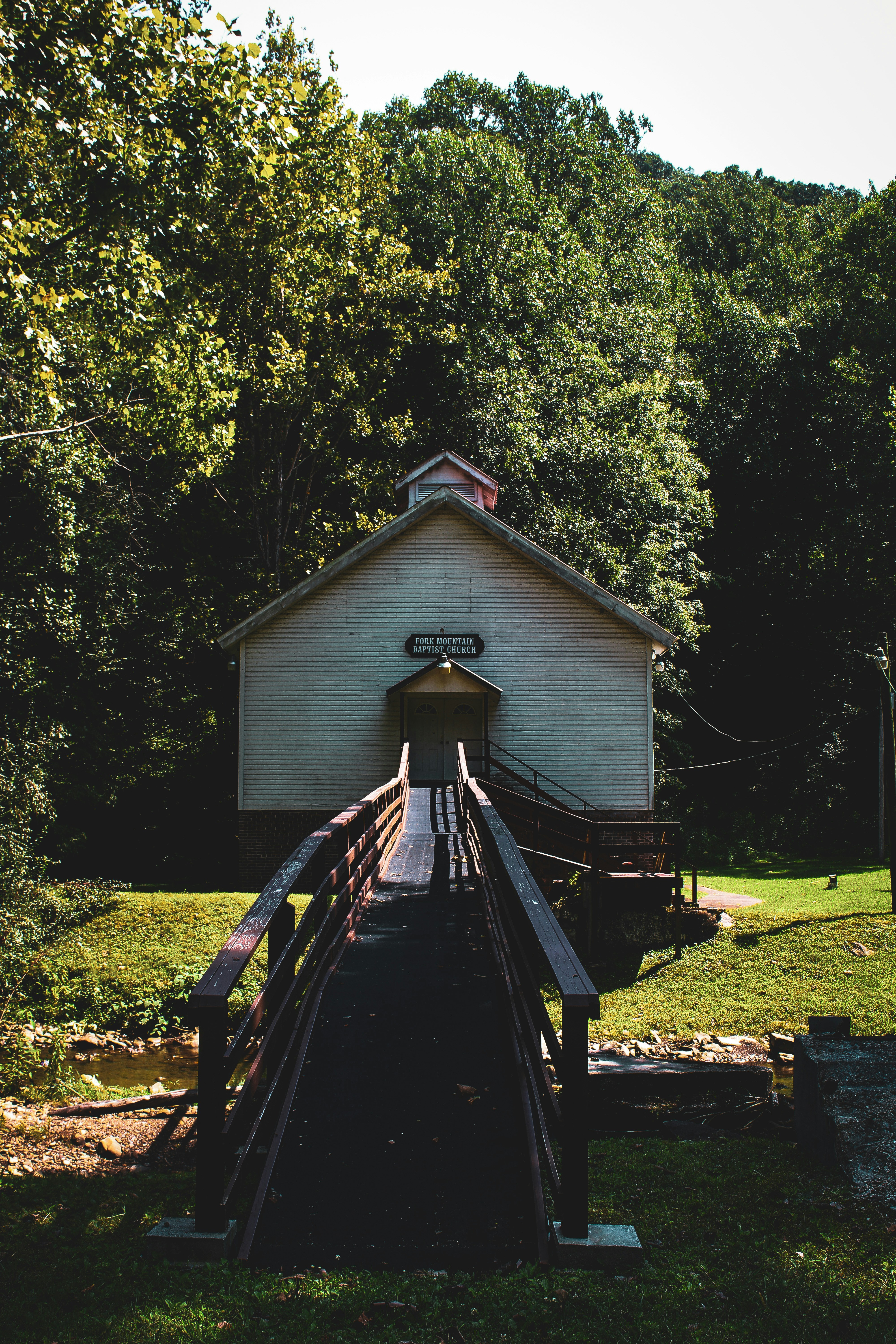 Bridge to the old mill: a wooden walkway leading to a modest riverside shed