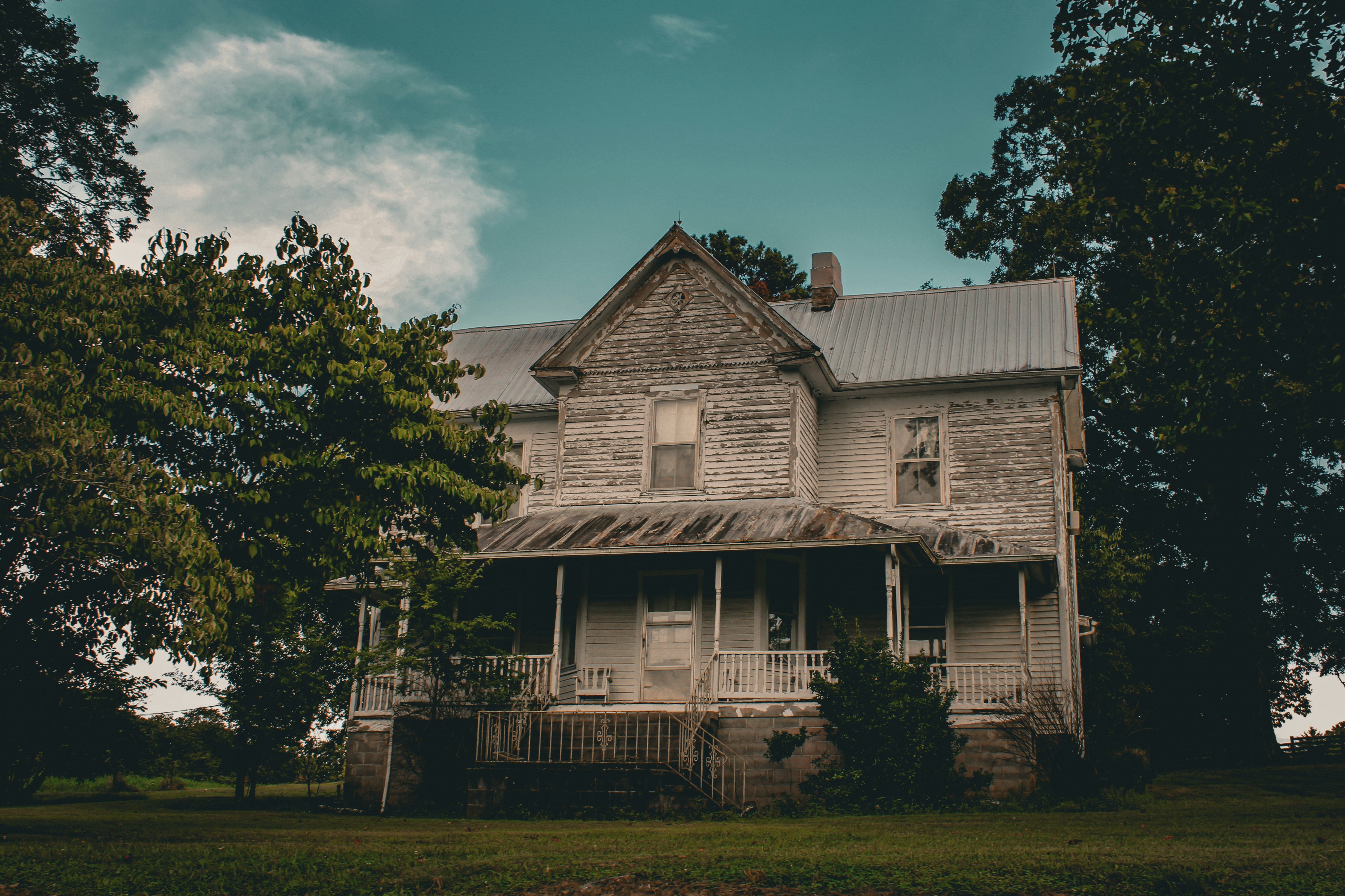 Haunted Porch: An Abandoned House Among Quiet Trees