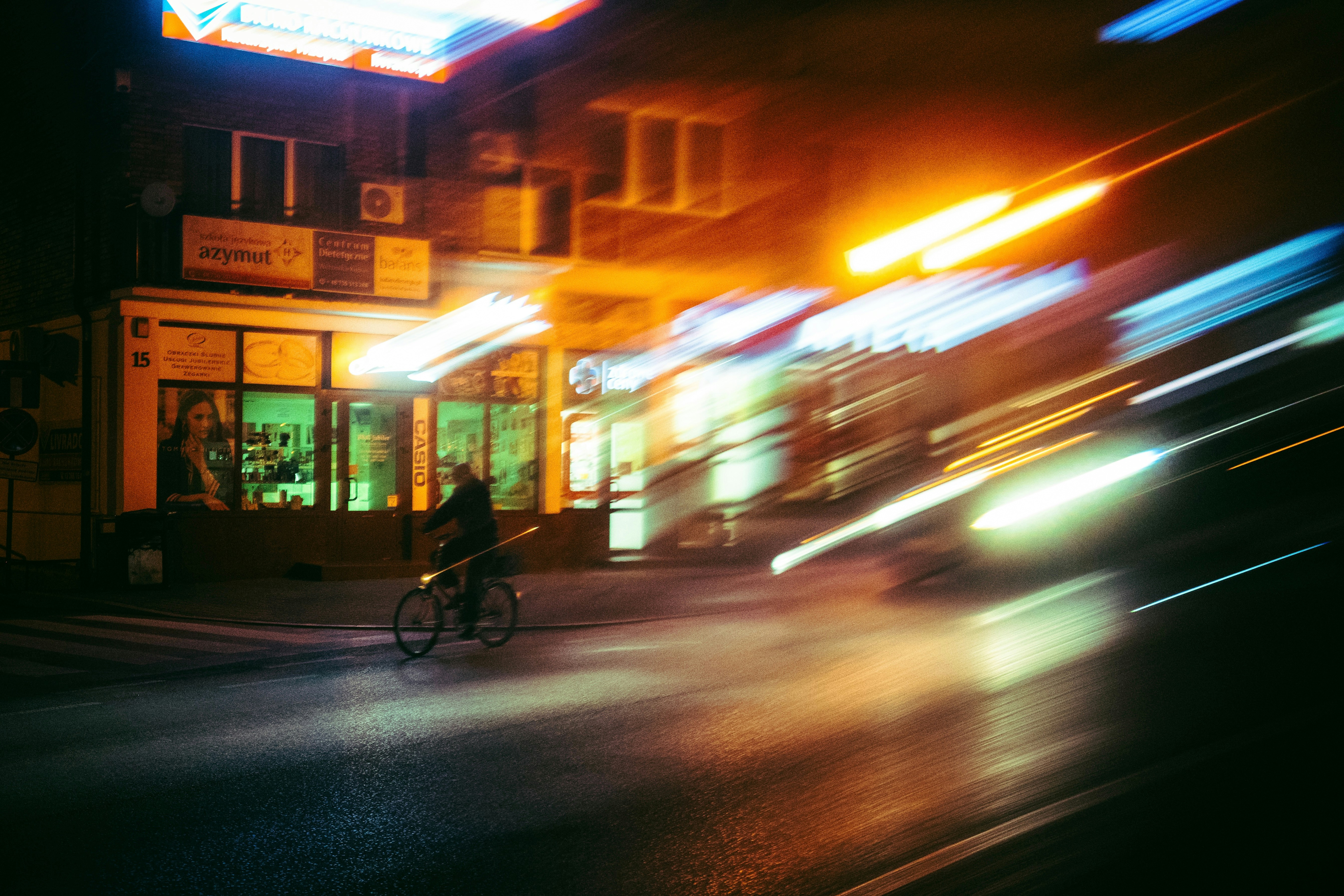 Midnight Blur: A Quiet Cyclist in a Neon-Stamped Street
