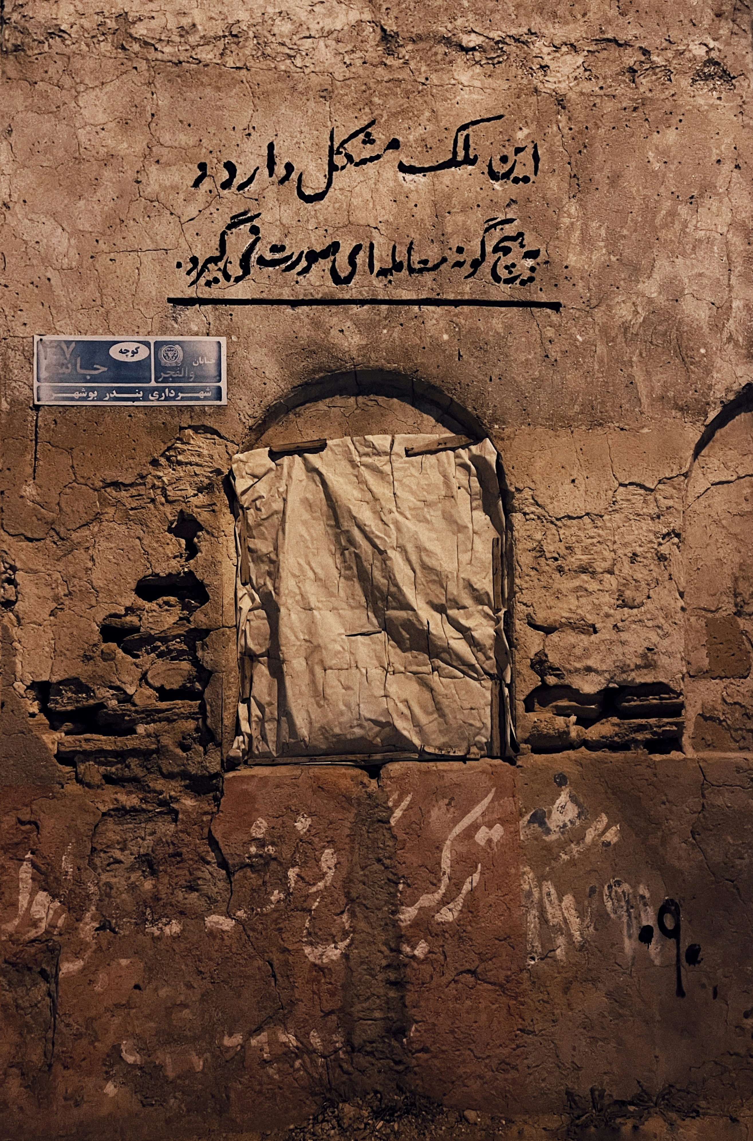 Hidden doorway under weathered wall: a doorway draped in cloth