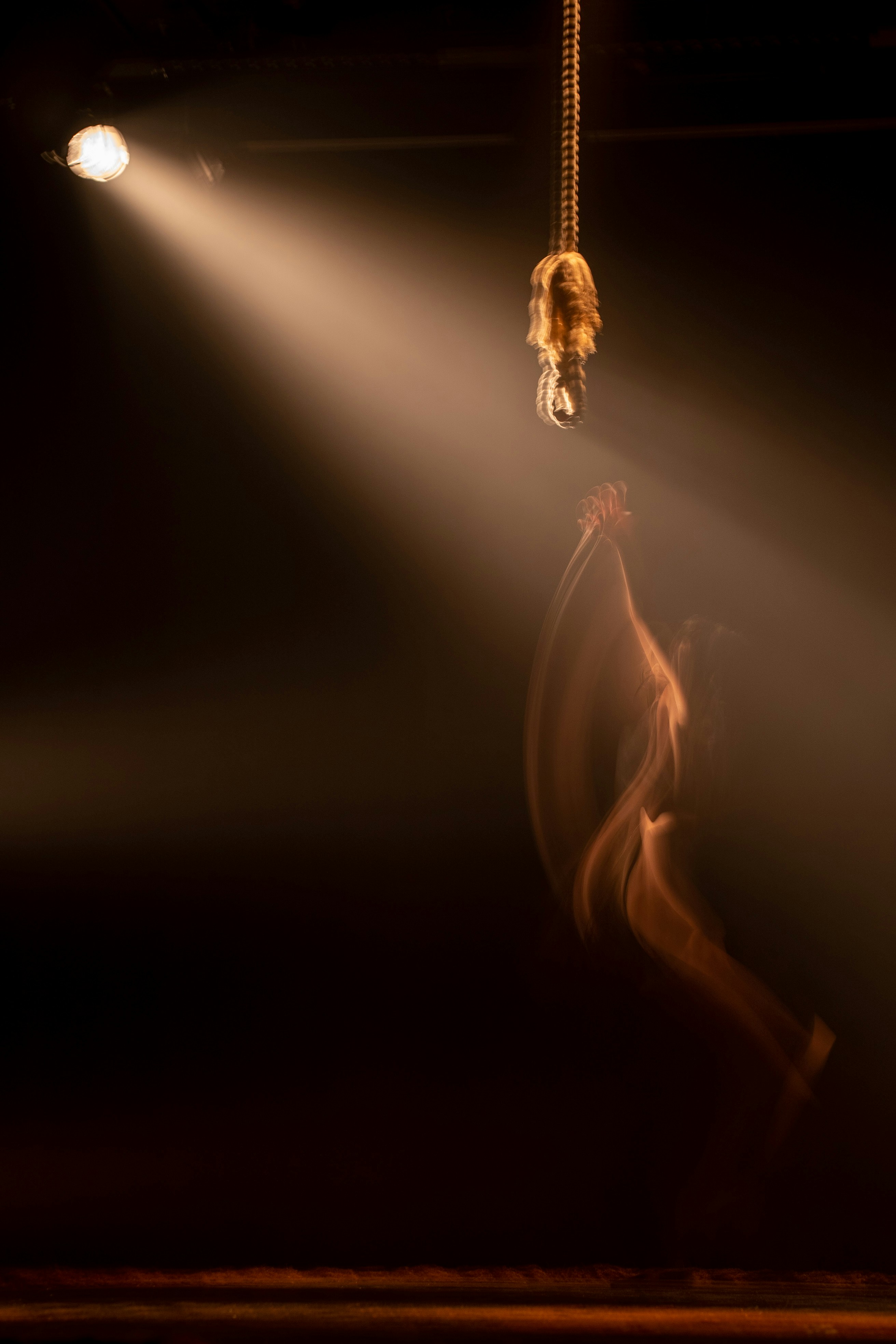 Shadowed Grace: A Silent Silhouette Beneath a Tethered Light