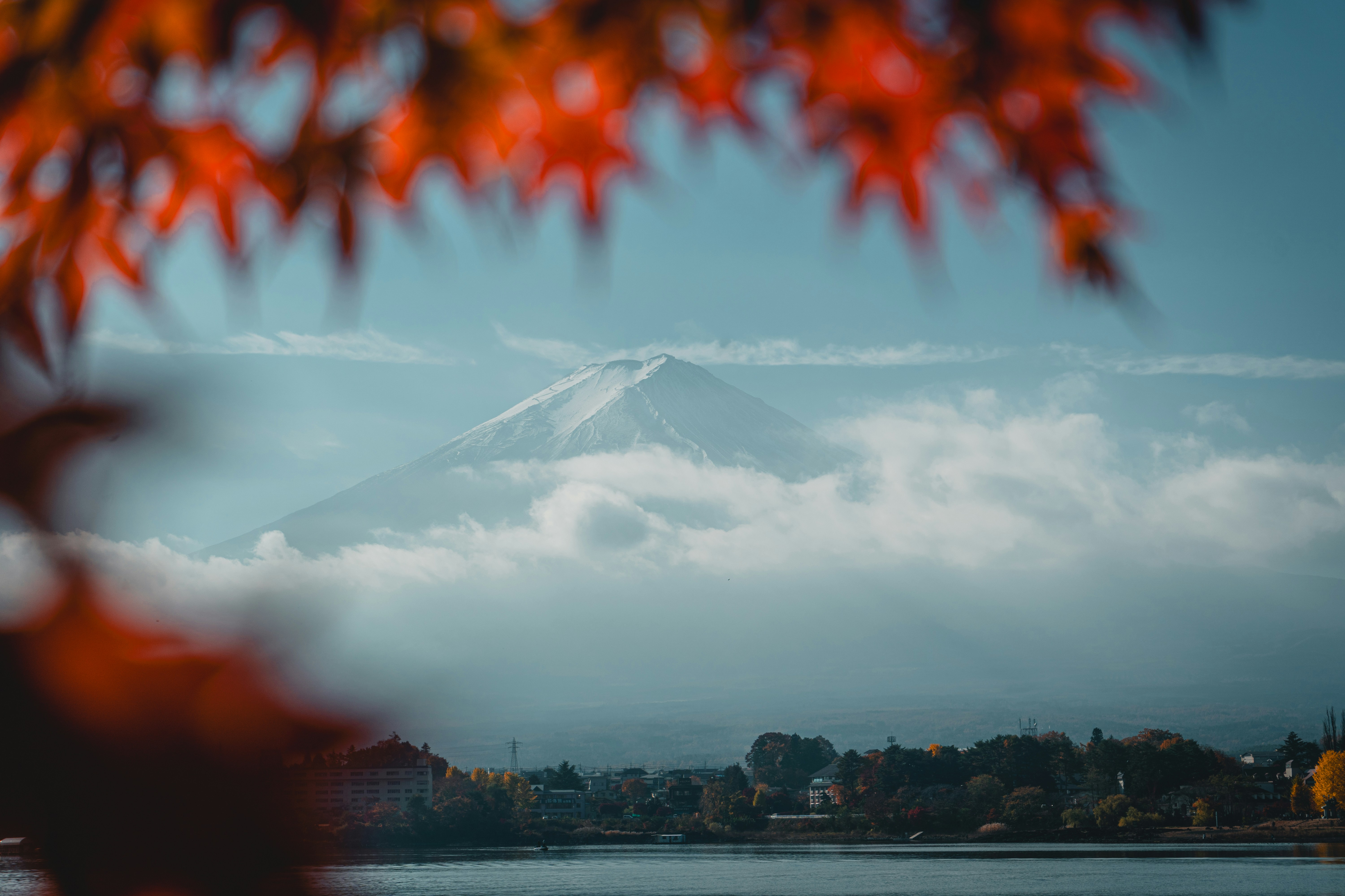 Mt. Fuji veiled in morning mist beyond a tranquil lakeside town