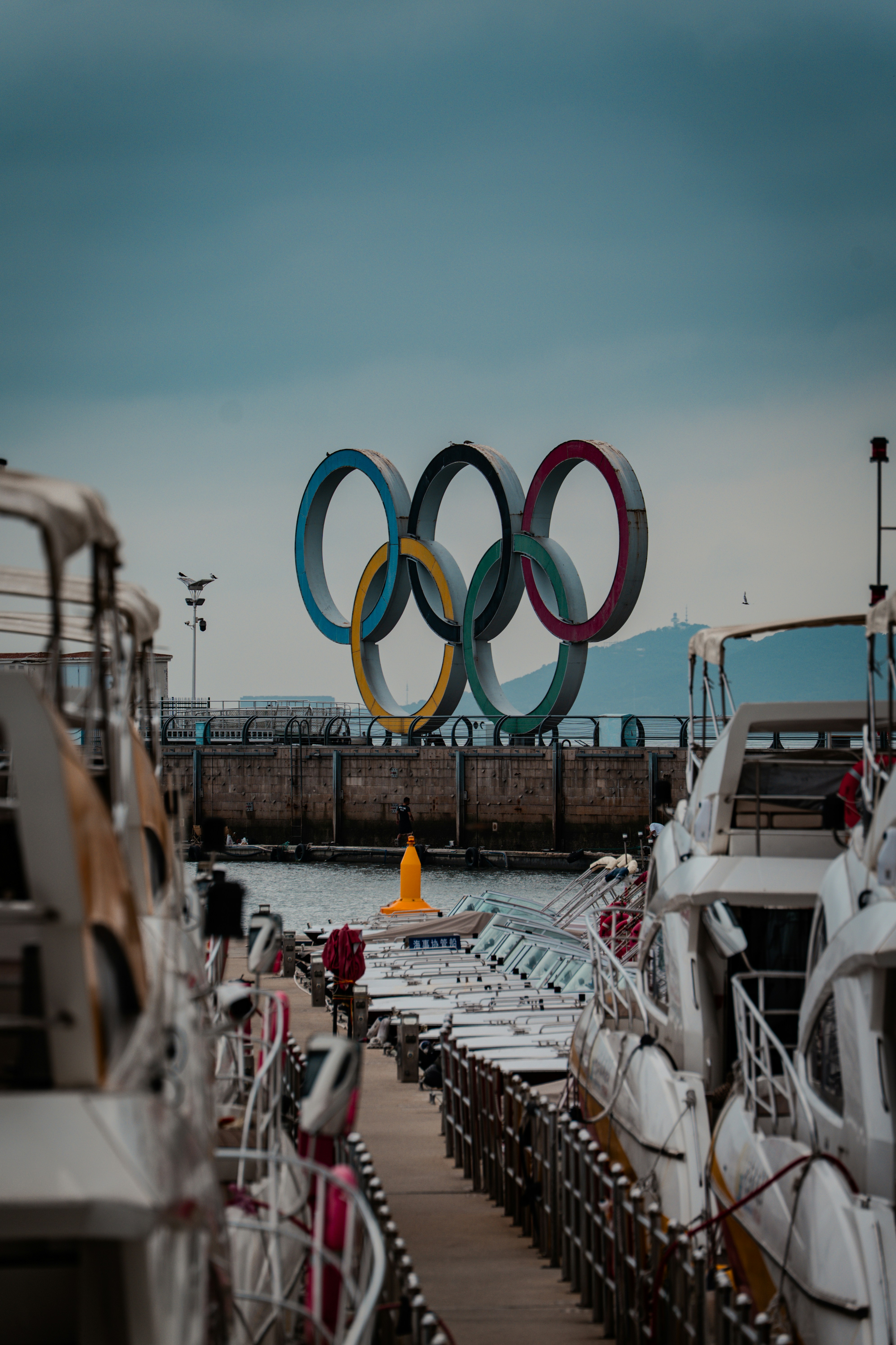 Olympic Rings Rising Over the Marina: A Fleet of Vessels Framing Victory