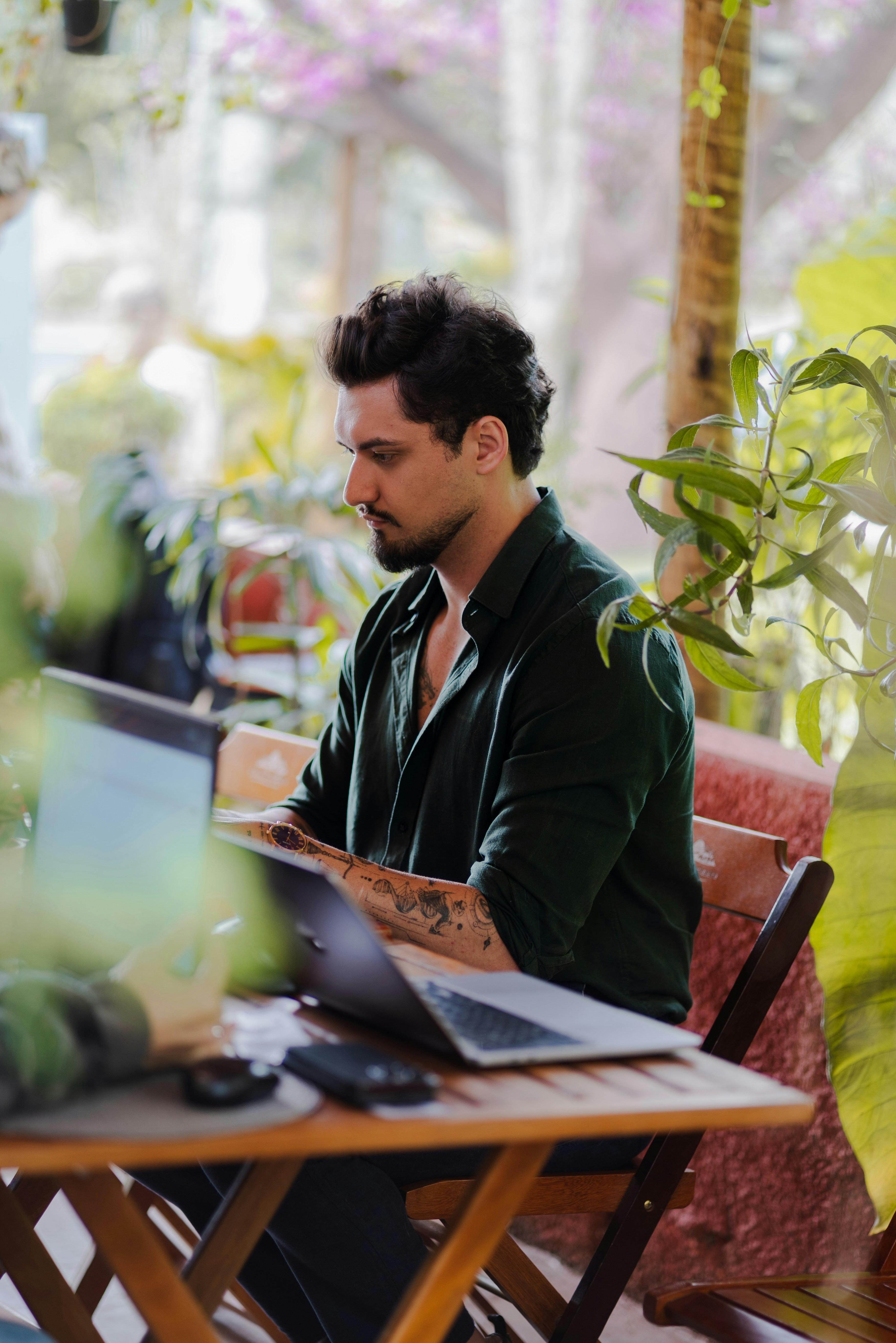 At a Sunlit Café, The Code of Focus: A Laptop, A Tattoo, A Moment