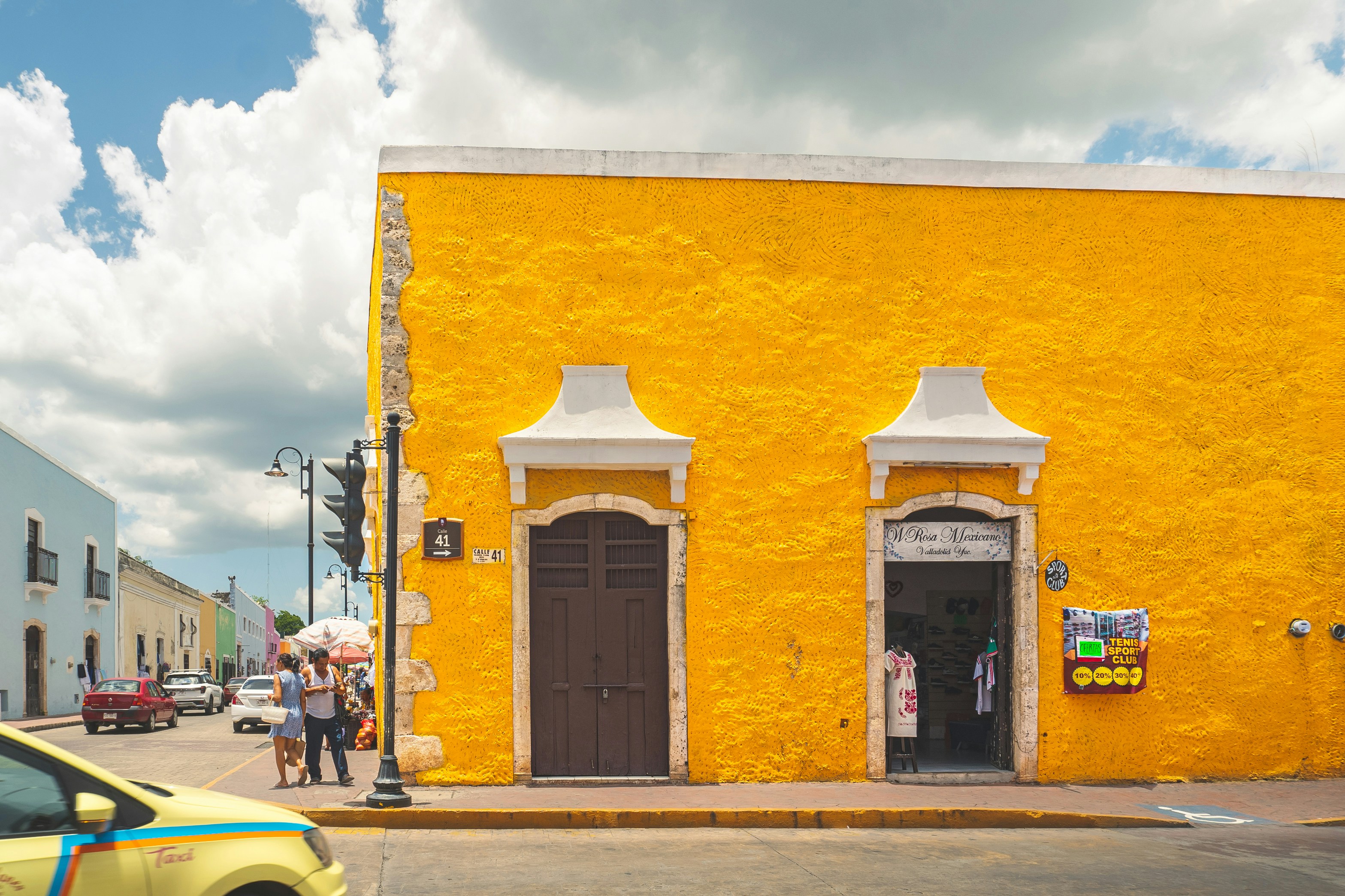 Bright Yellow Facade, Quiet Street, and Lively Shopfronts