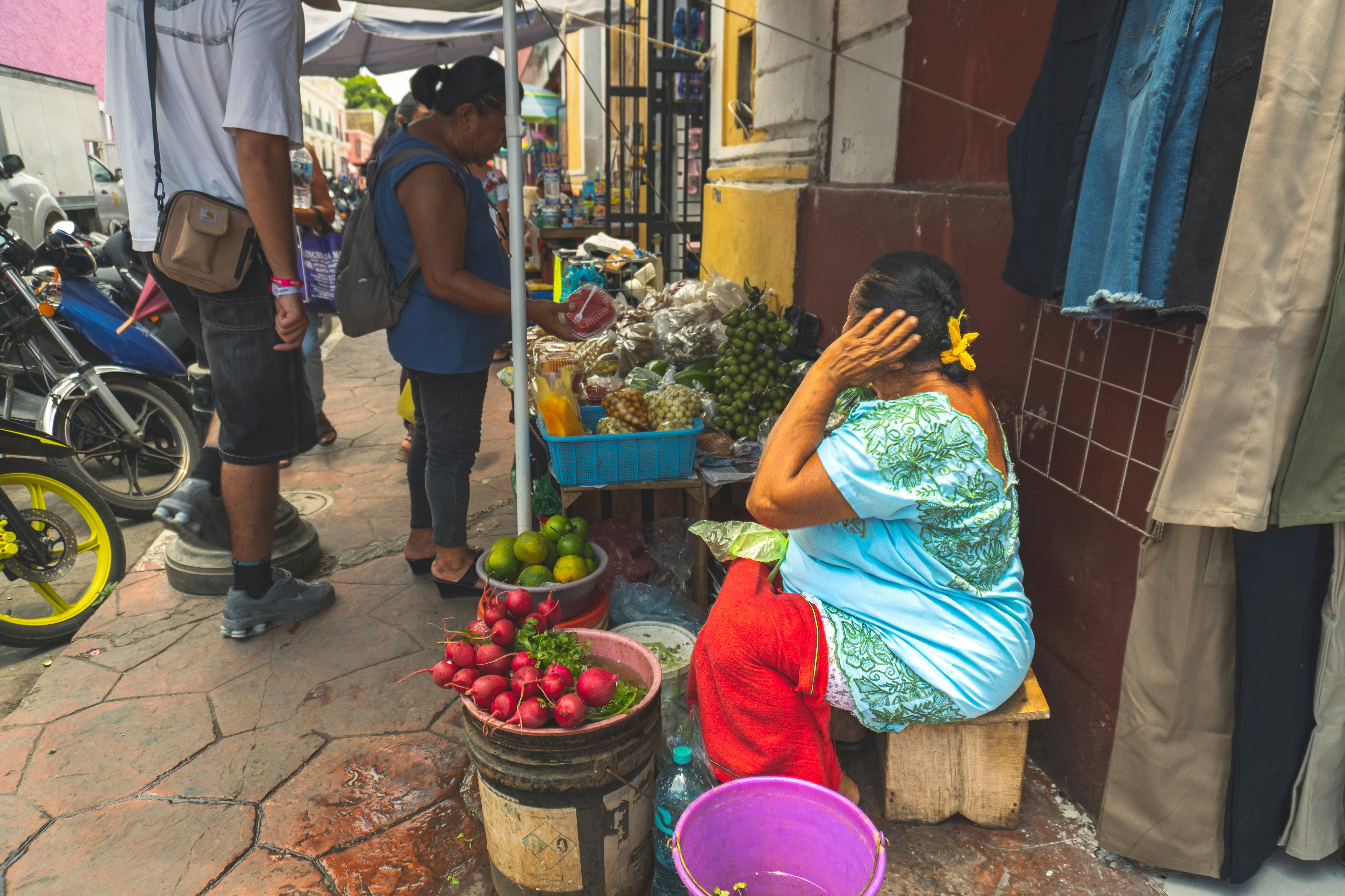 Market Portrait: Colorful Street Vendor Amid Stacked Produce