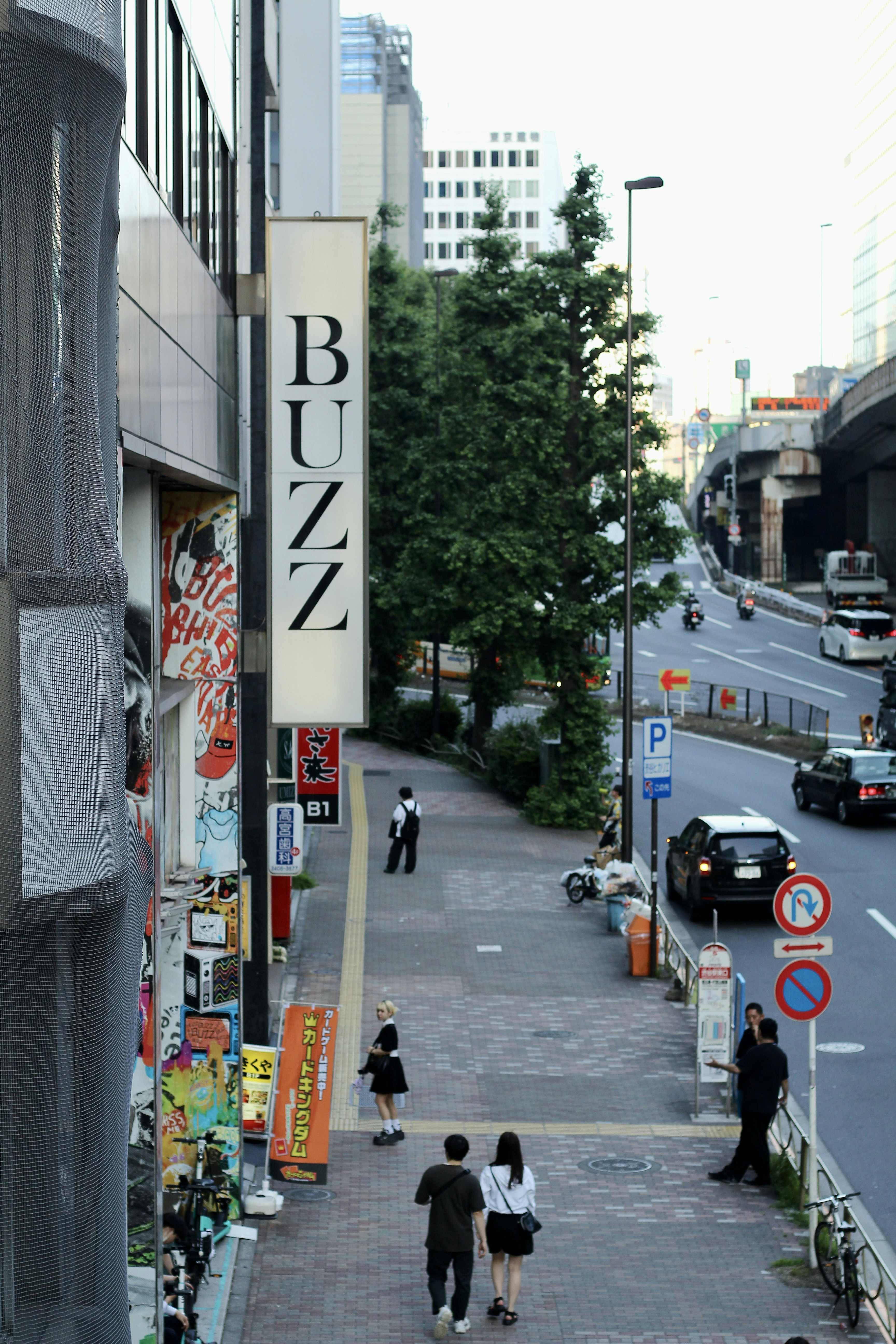 Urban Canvas: People Walk the Quiet Axis of a Buzzing Street
