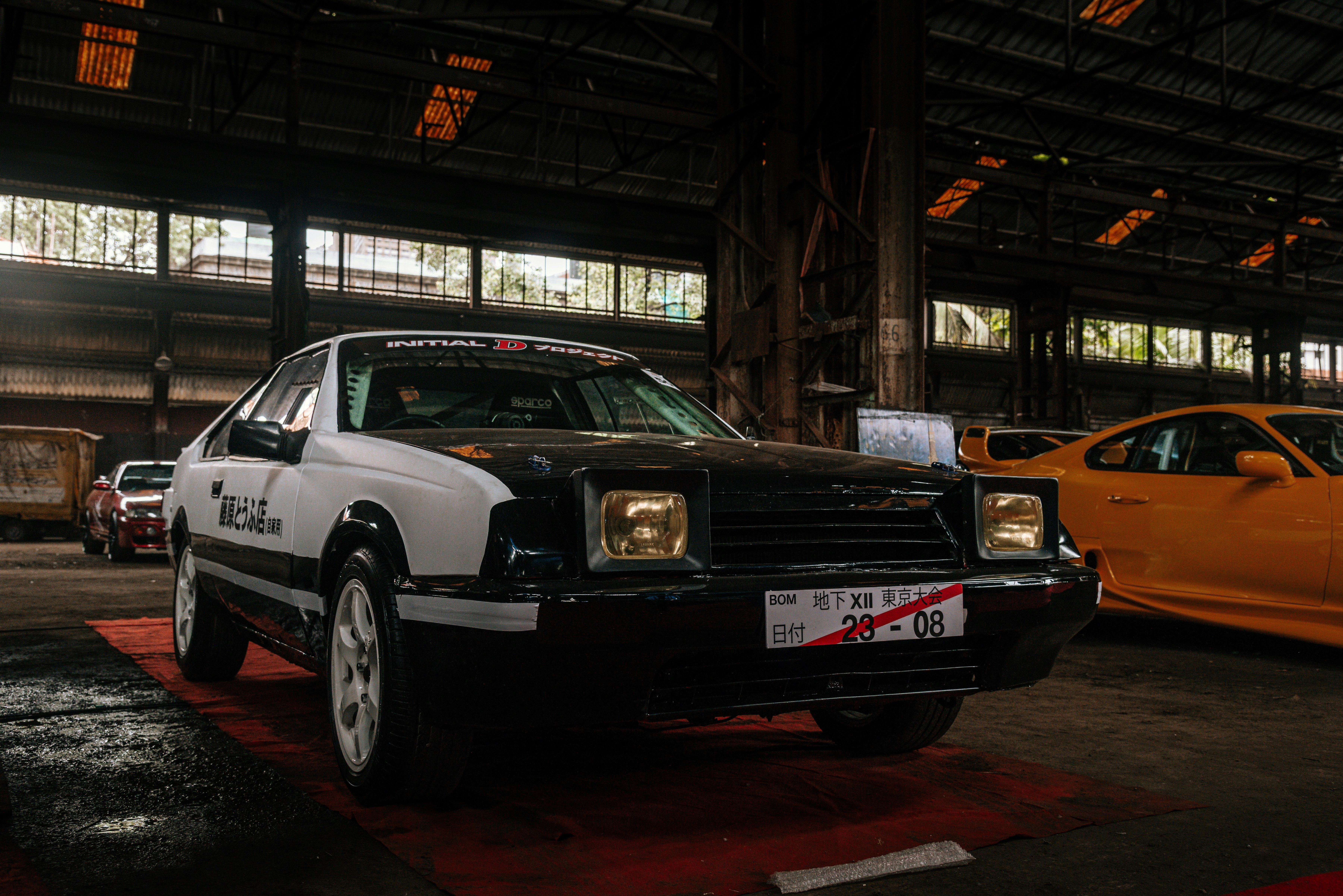 Midnight showroom: A white rally coupe under sparse hangar light