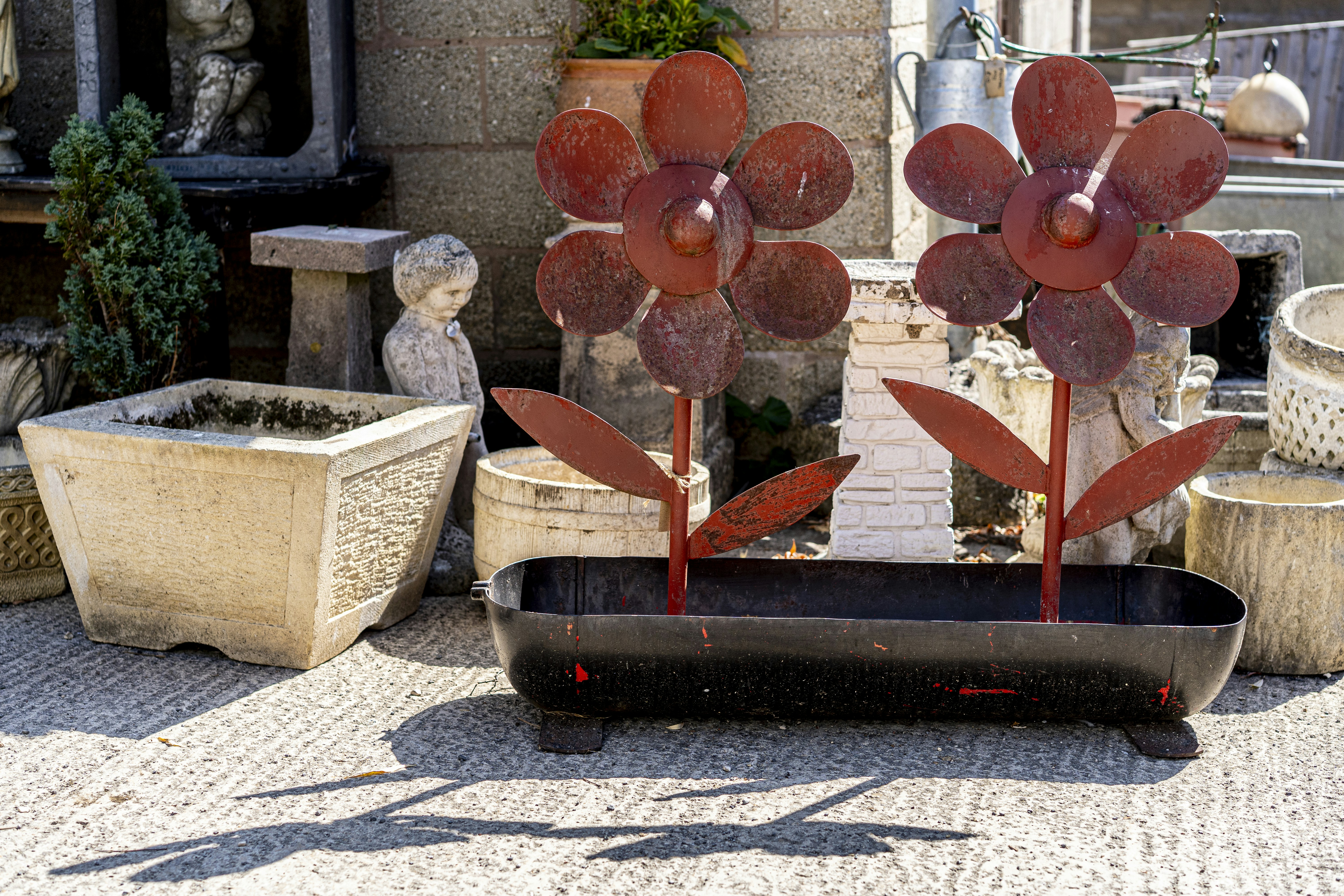 Rusty Garden Dunes: Metal Flowers Amid Ceramic Planters