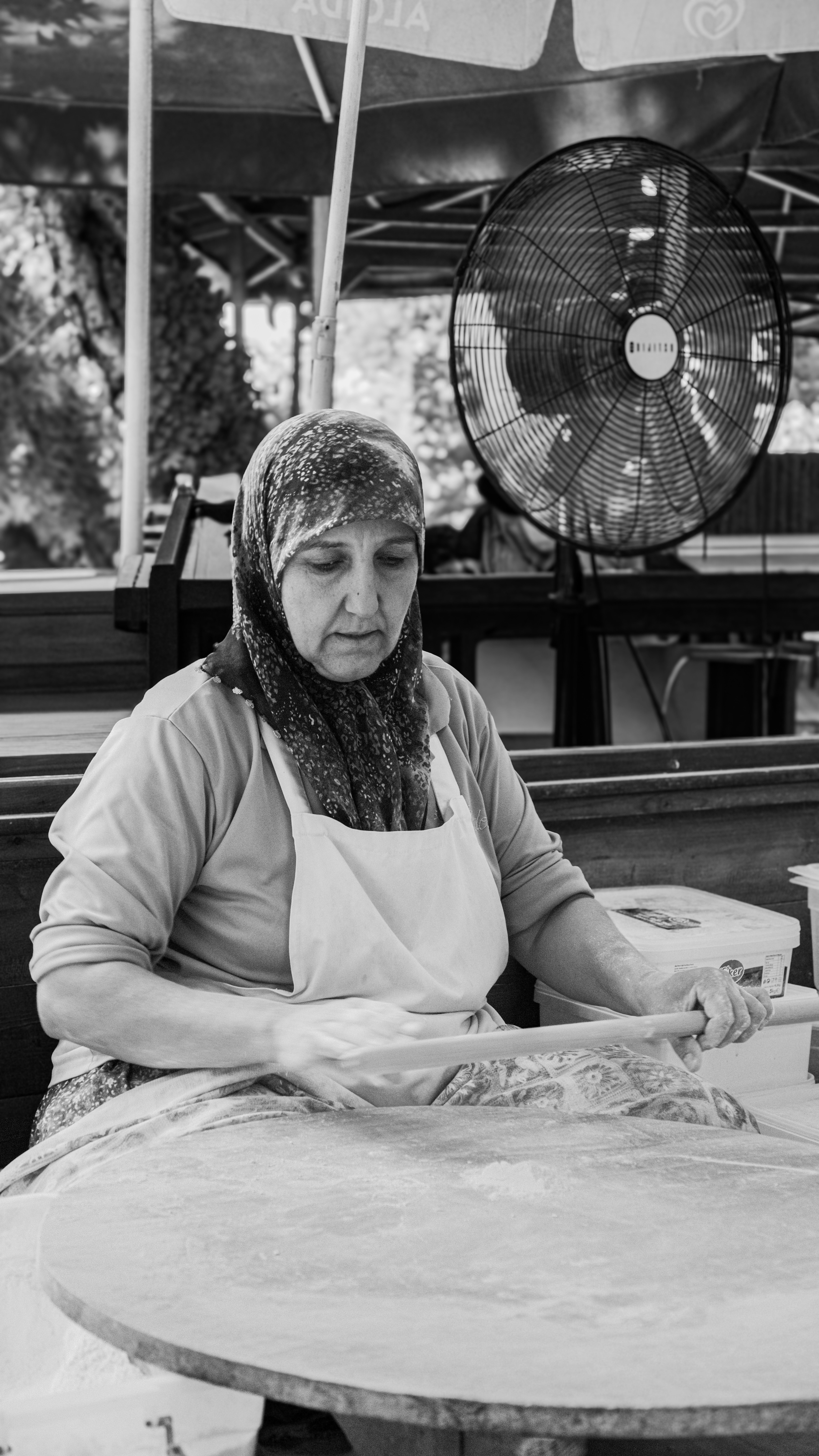 The Battered Dough: A Woman Rolling Dough Under a Cooling Fan
