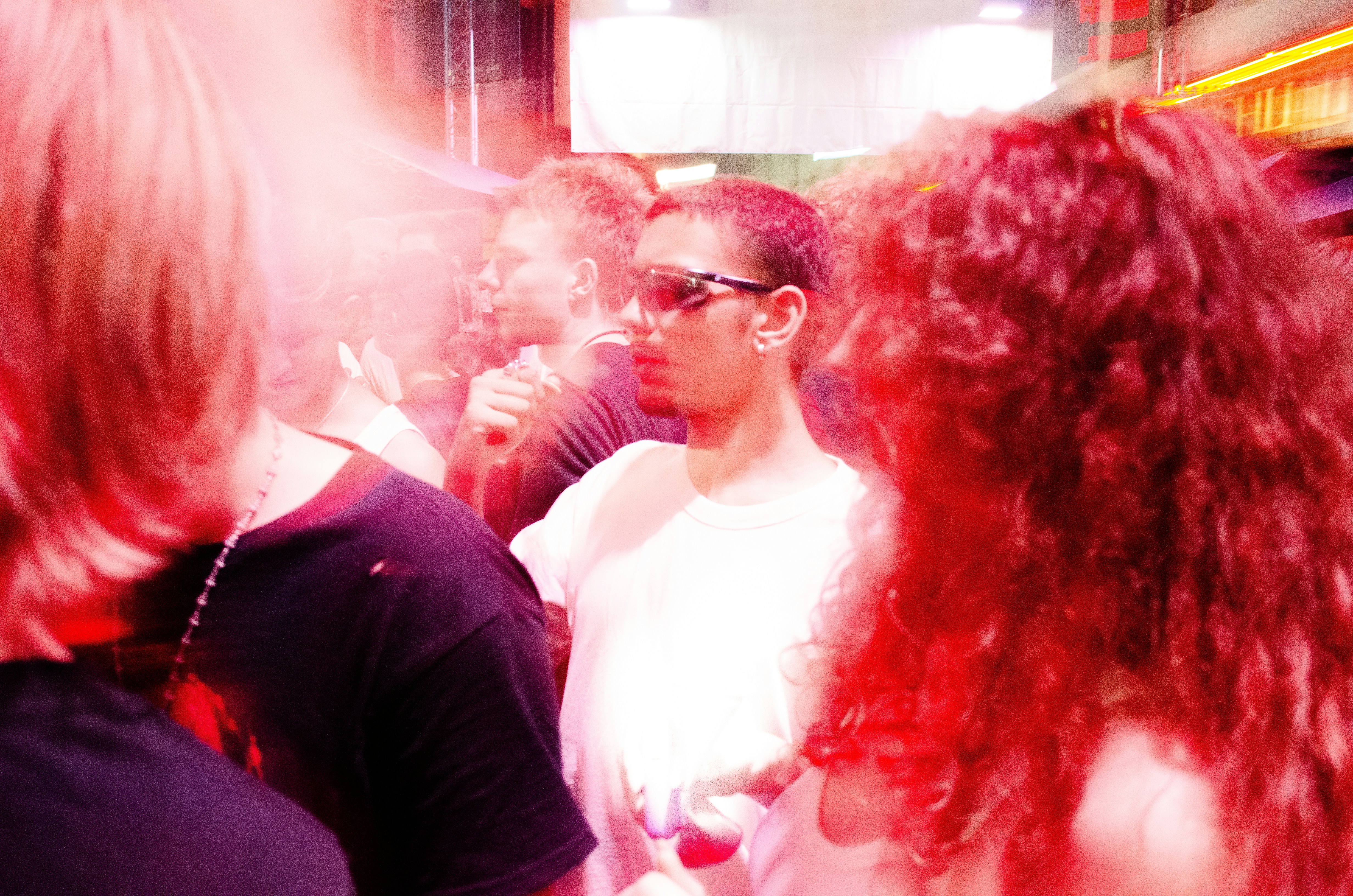 Neon Night in the Crowd: A Glimmer of Focus Among the Red Lights