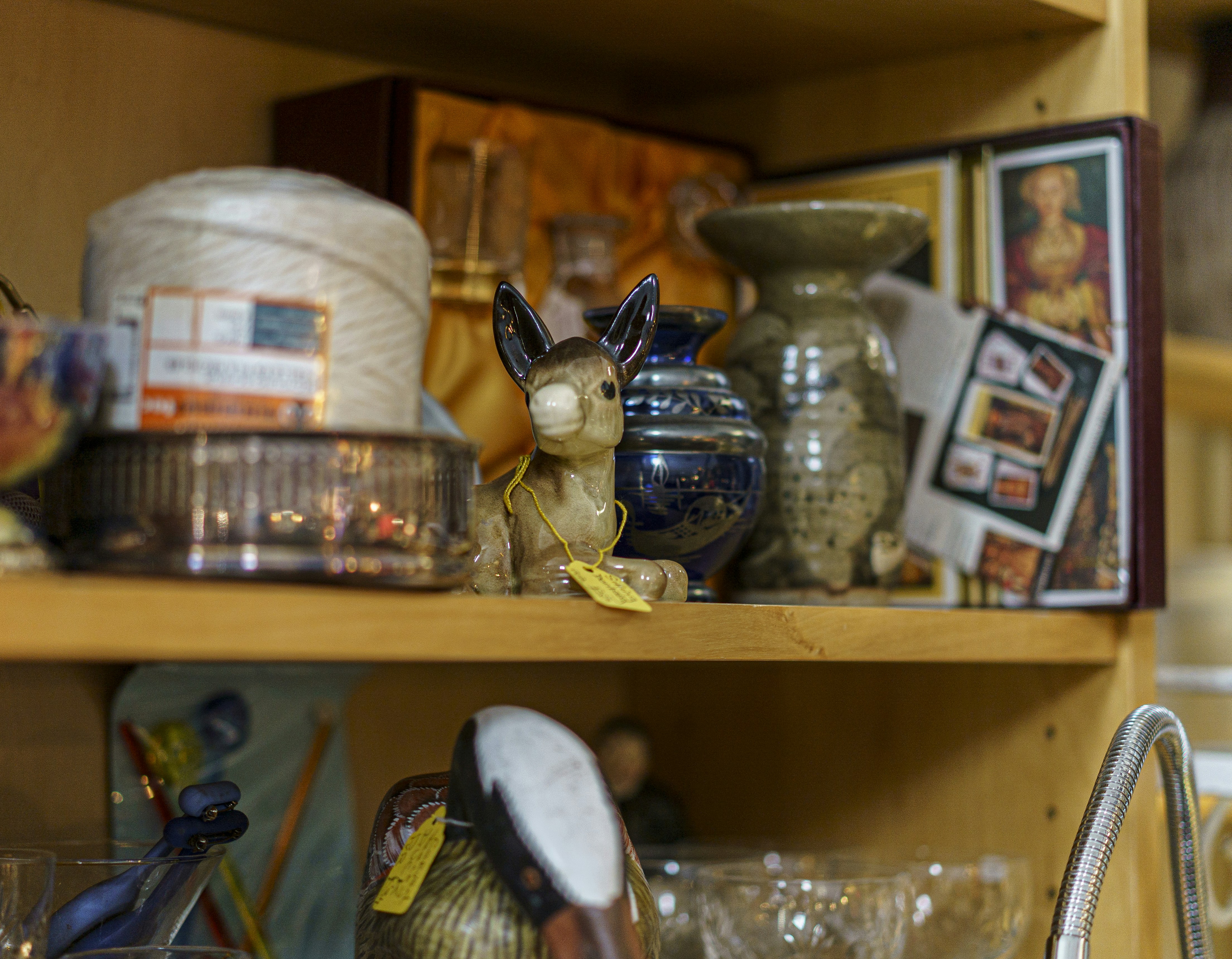 Ceramic Shelf: A Small Figurine Amid Vintage Pottery