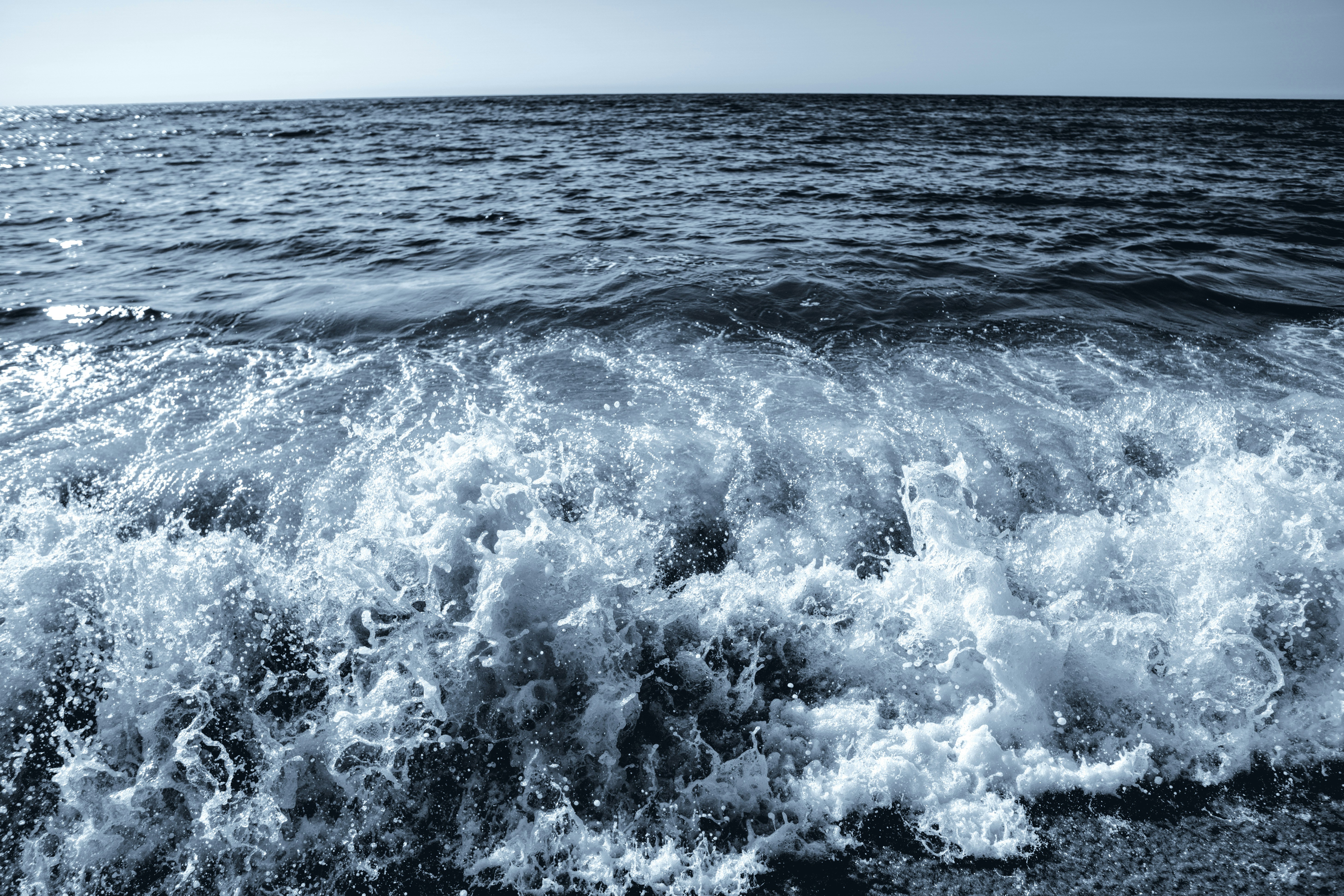 Edge of the Line: Foamy breakers under a calm horizon