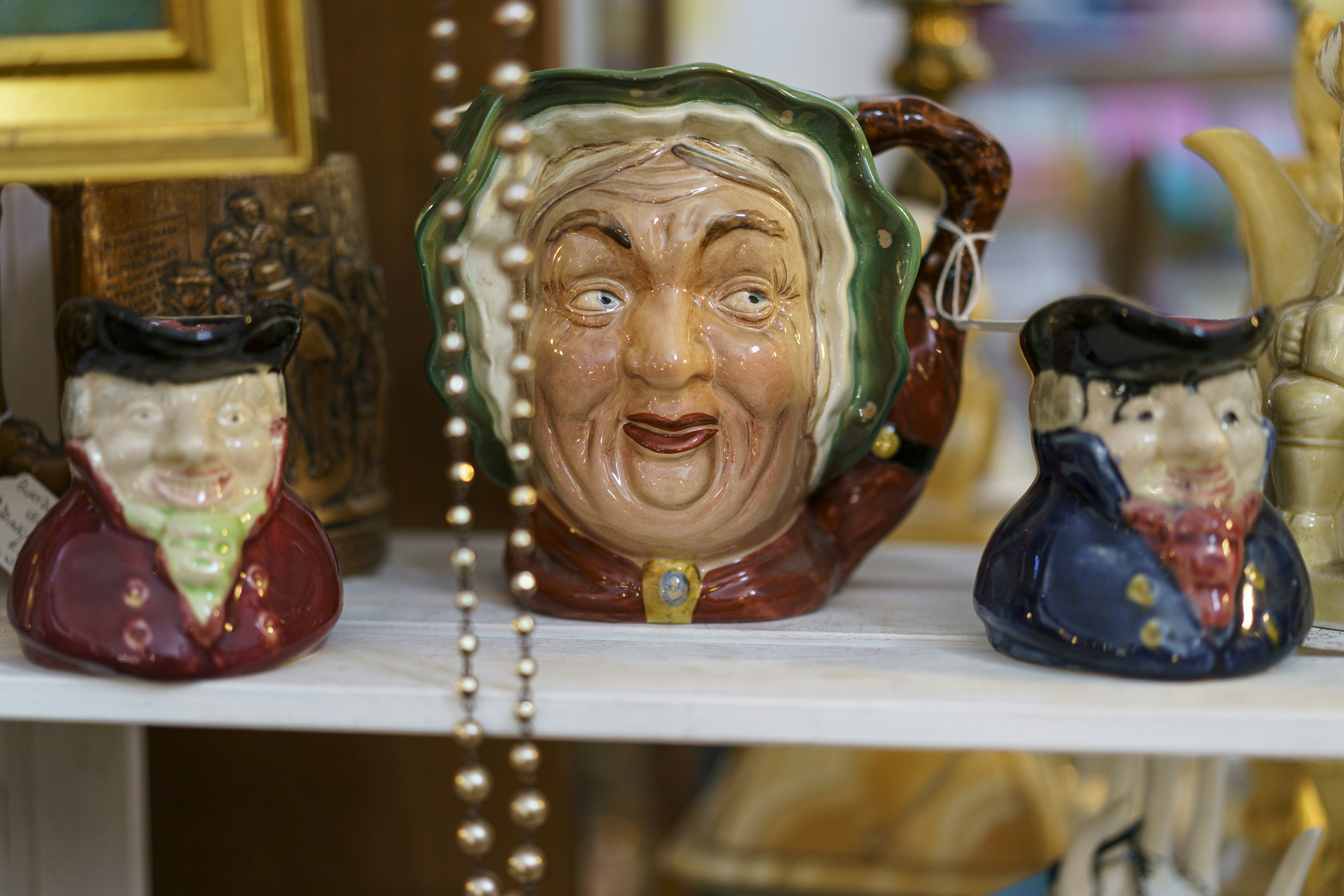 Whimsical Mug Trio: A Timeworn Smile Among Ceramic Companions