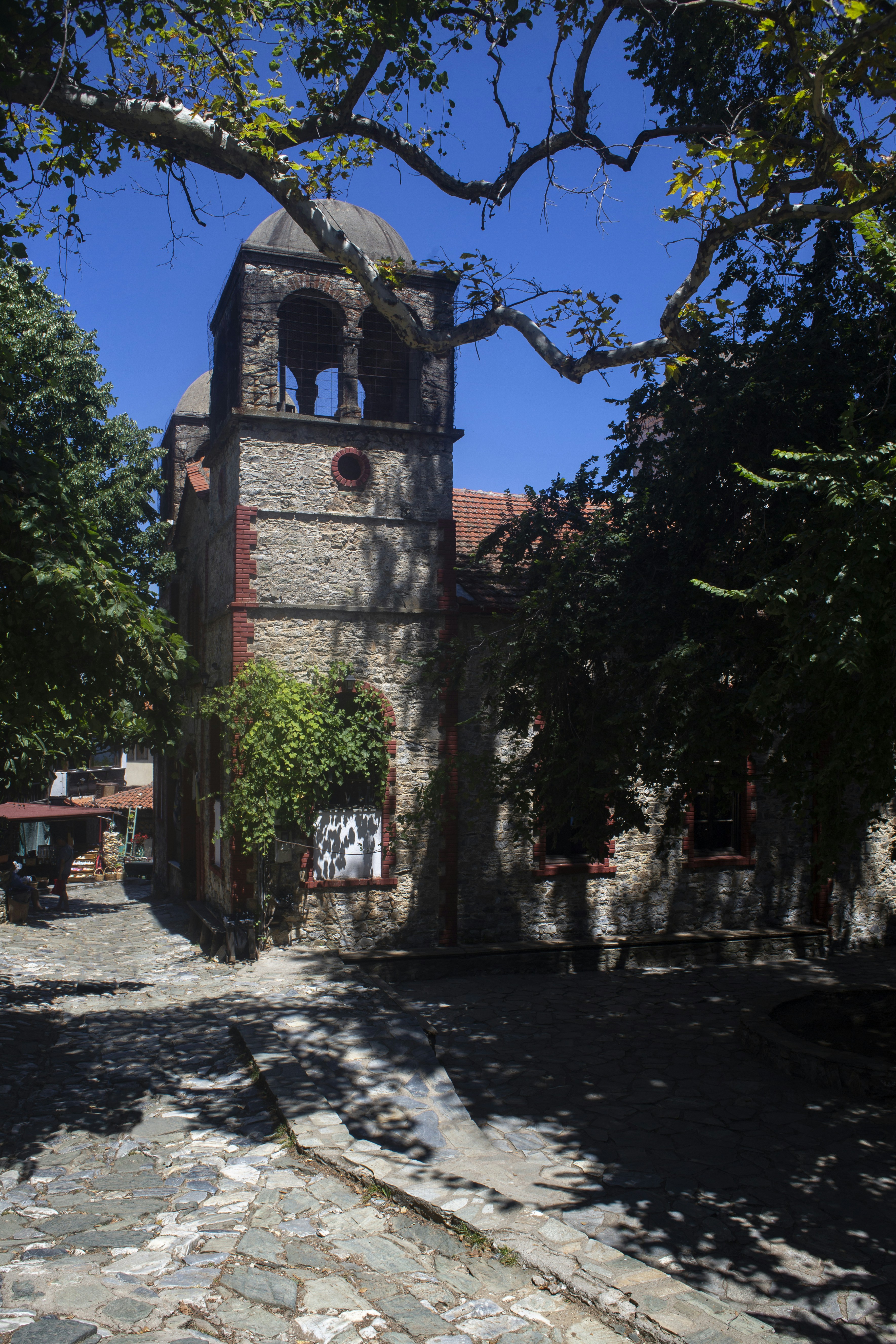 Stone Bell-Tower Quiet Between Dappled Shadows