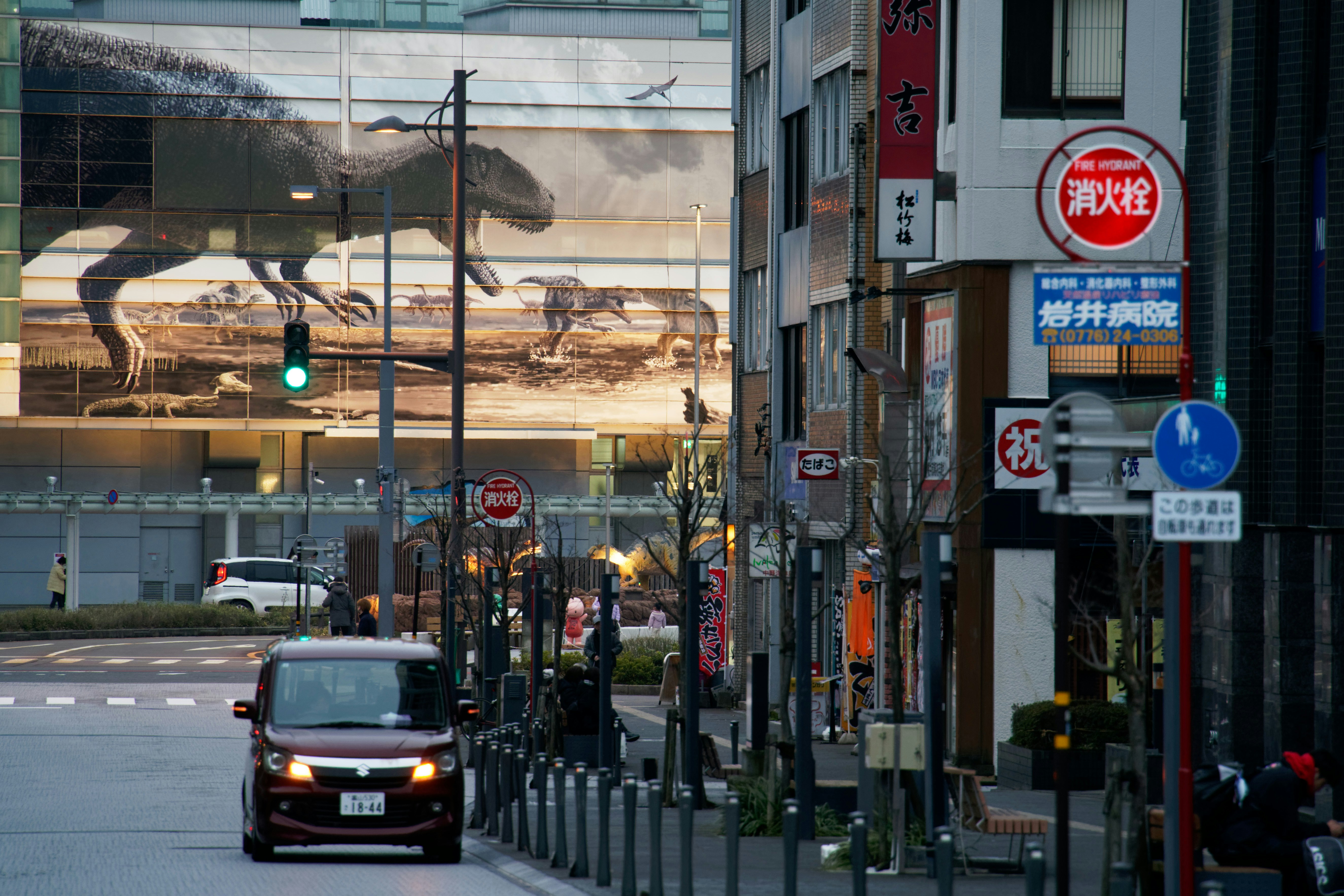 Street in Focus: A Car Passes Beneath a Mammoth Wall Mural